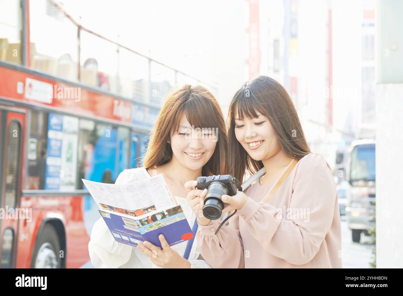 Women looking at guidebook Stock Photo - Alamy