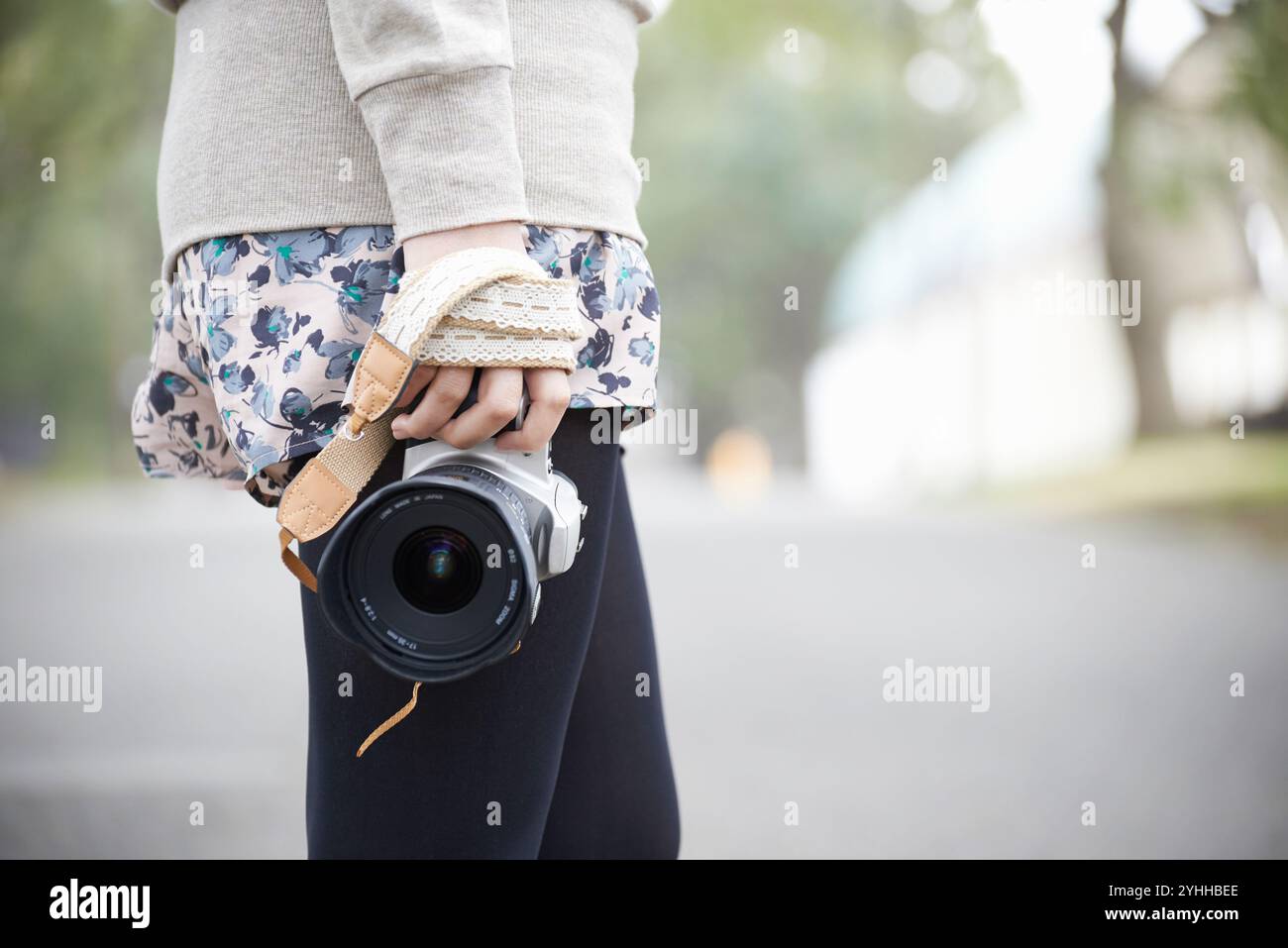 Woman holding camera in one hand Stock Photo - Alamy