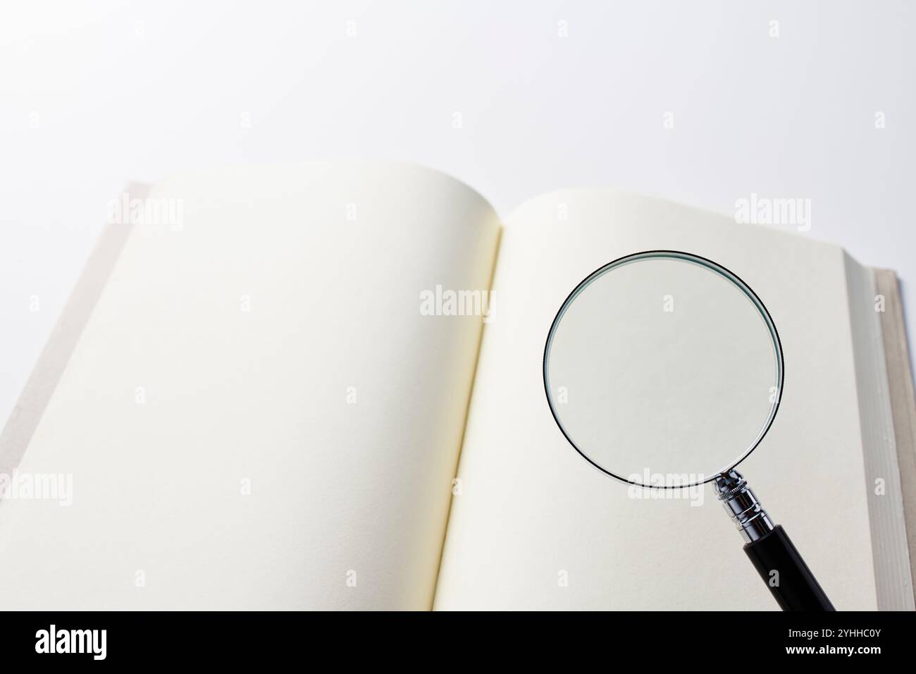 Magnifying glass and book Stock Photo - Alamy
