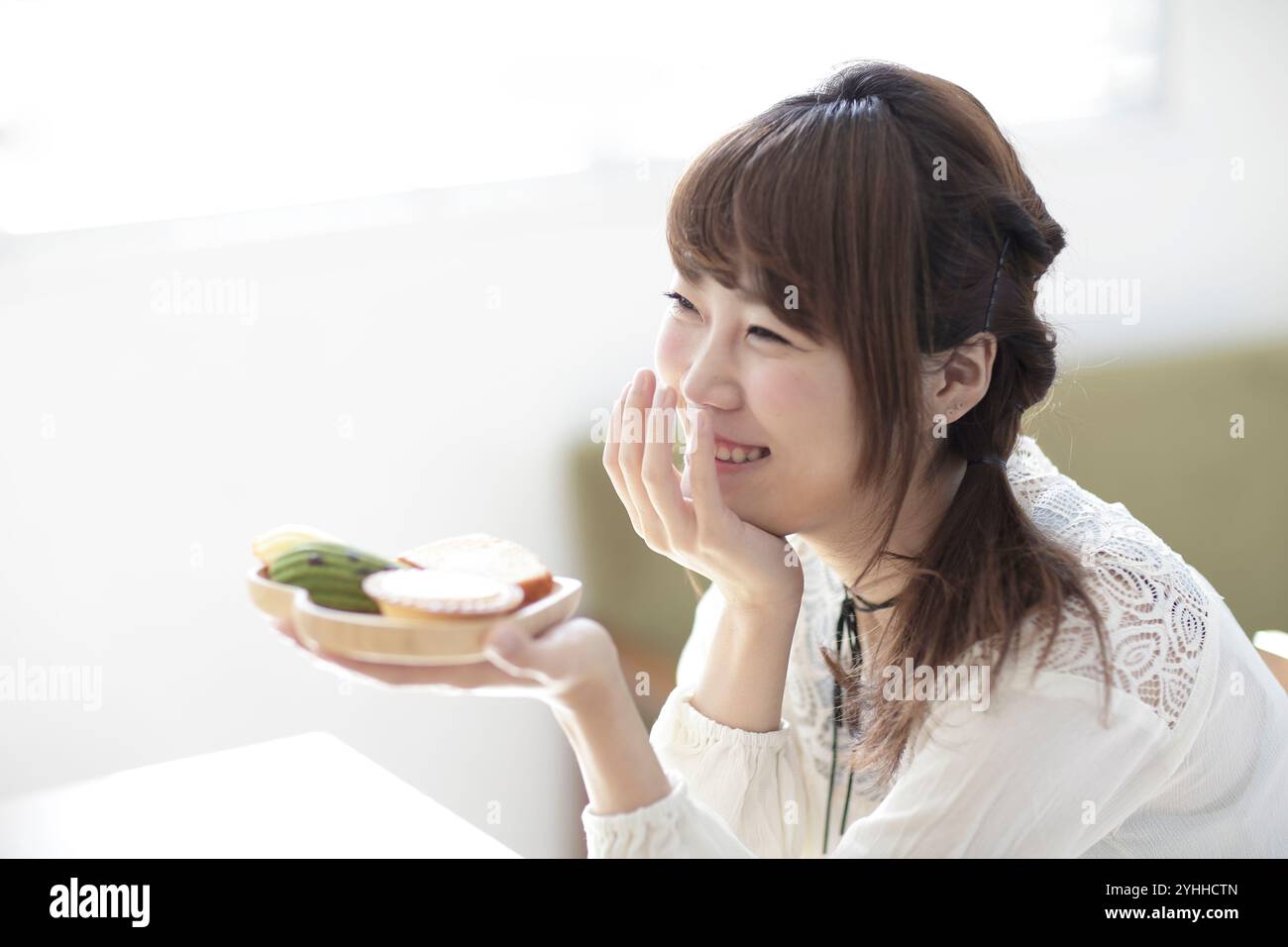 College student holding cake in her hand Stock Photo - Alamy