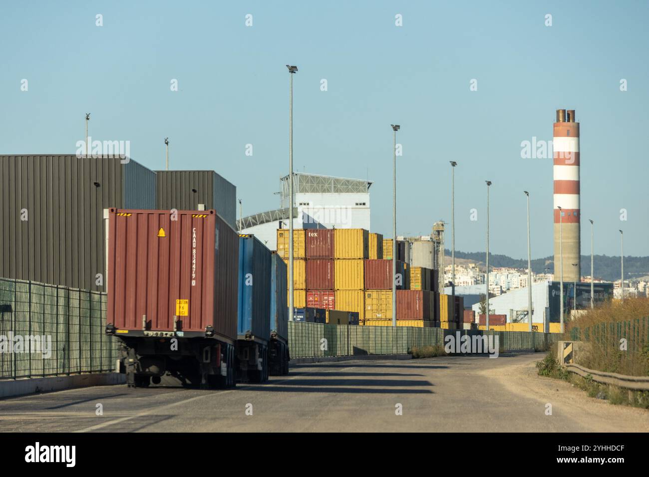 Truck carrying colorful intermodal containers exiting industrial port ...