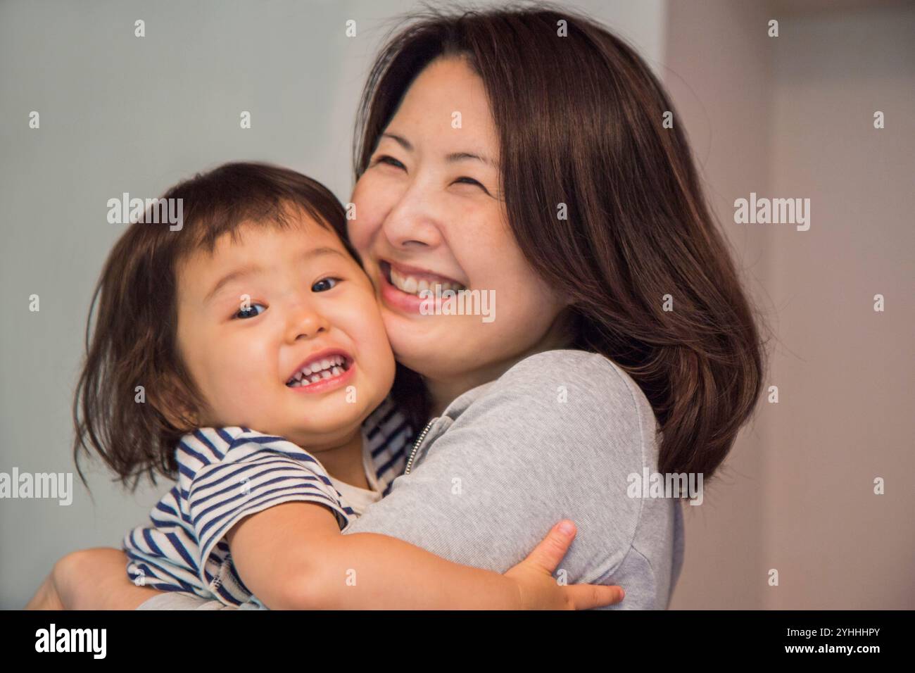 Mother rubbing cheeks on child Stock Photo - Alamy