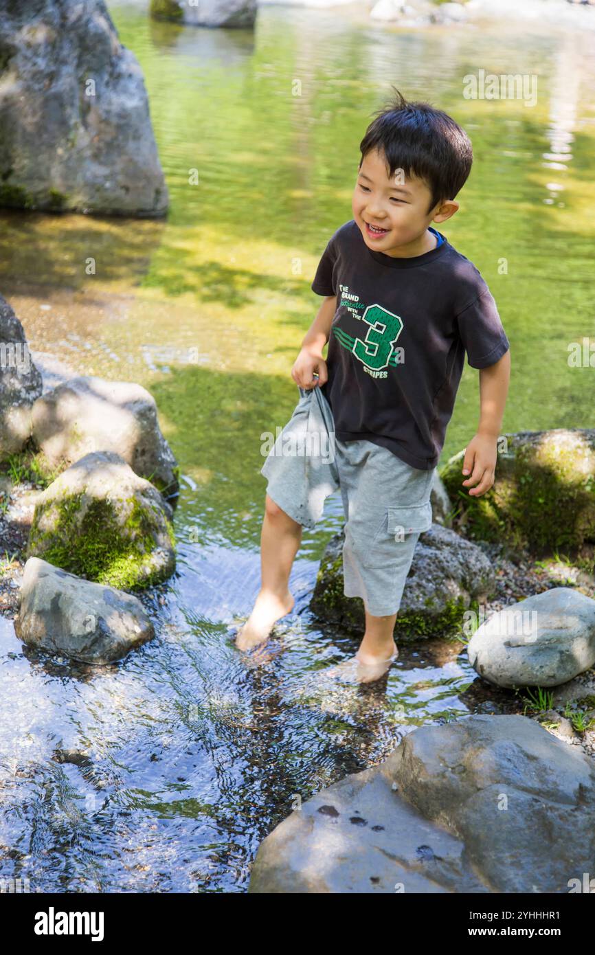 Boy putting his feet in pond Stock Photo - Alamy