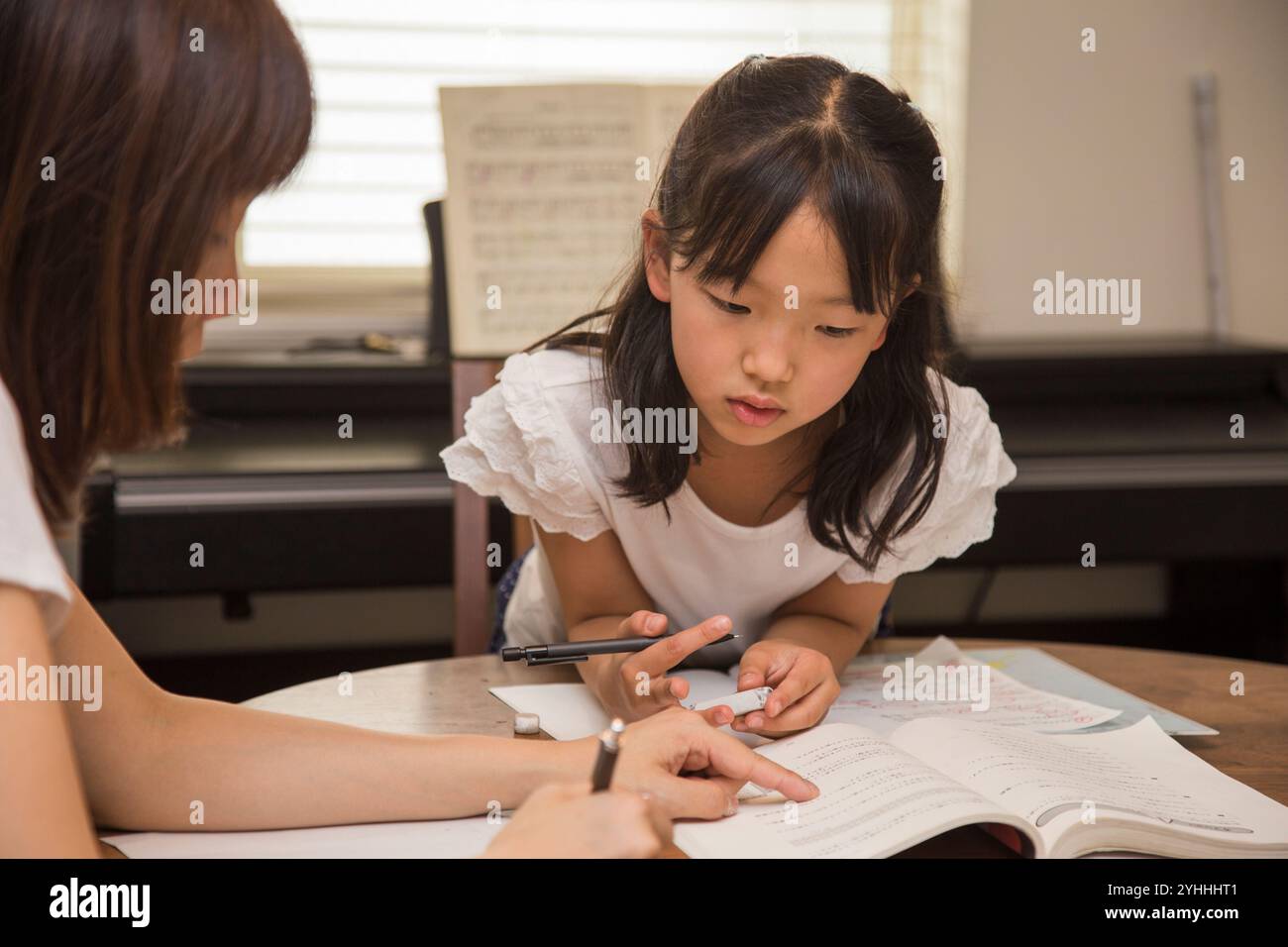 Child being taught to study by her mother Stock Photo - Alamy