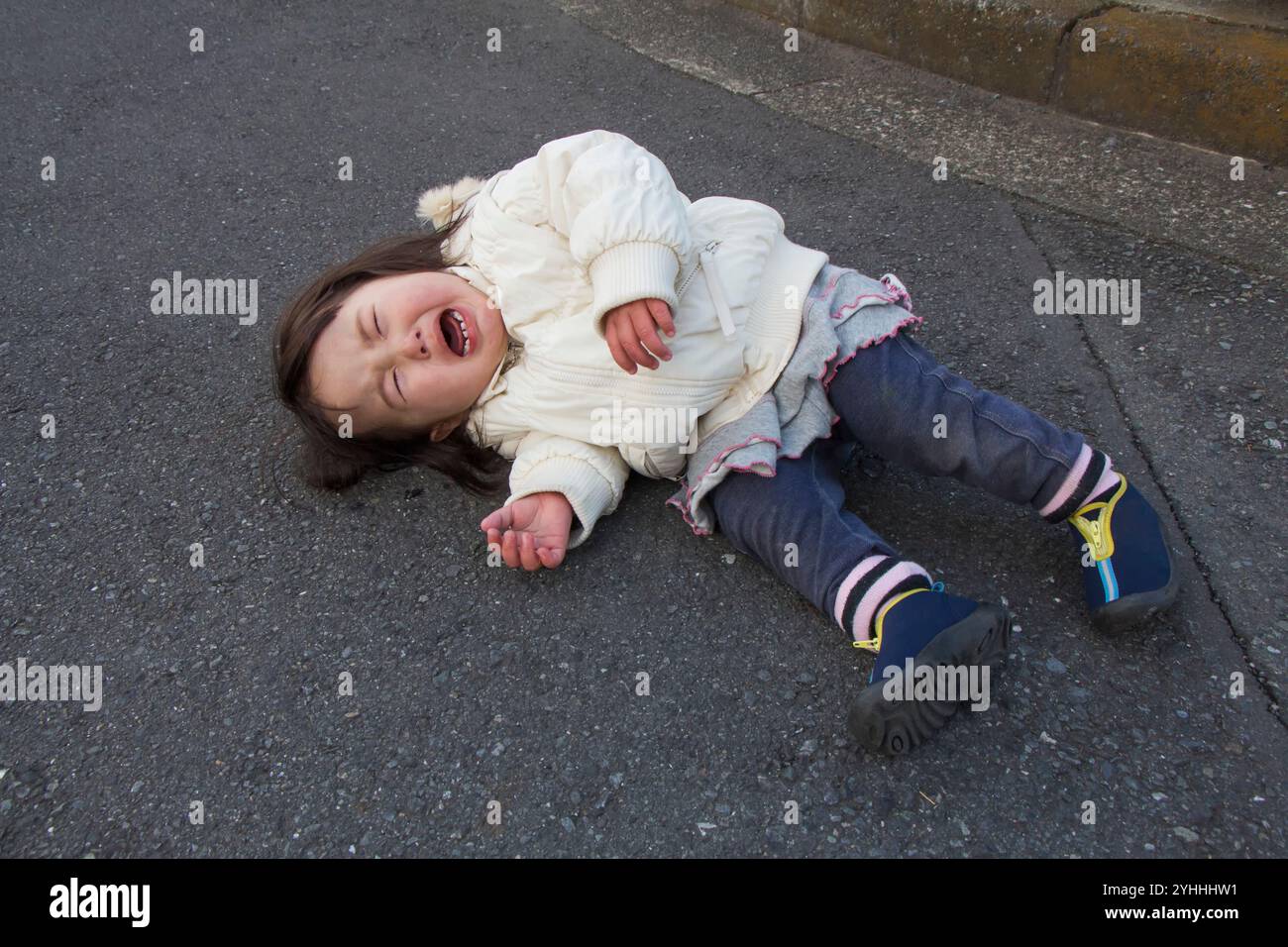 Girl lying on the road crying Stock Photo - Alamy