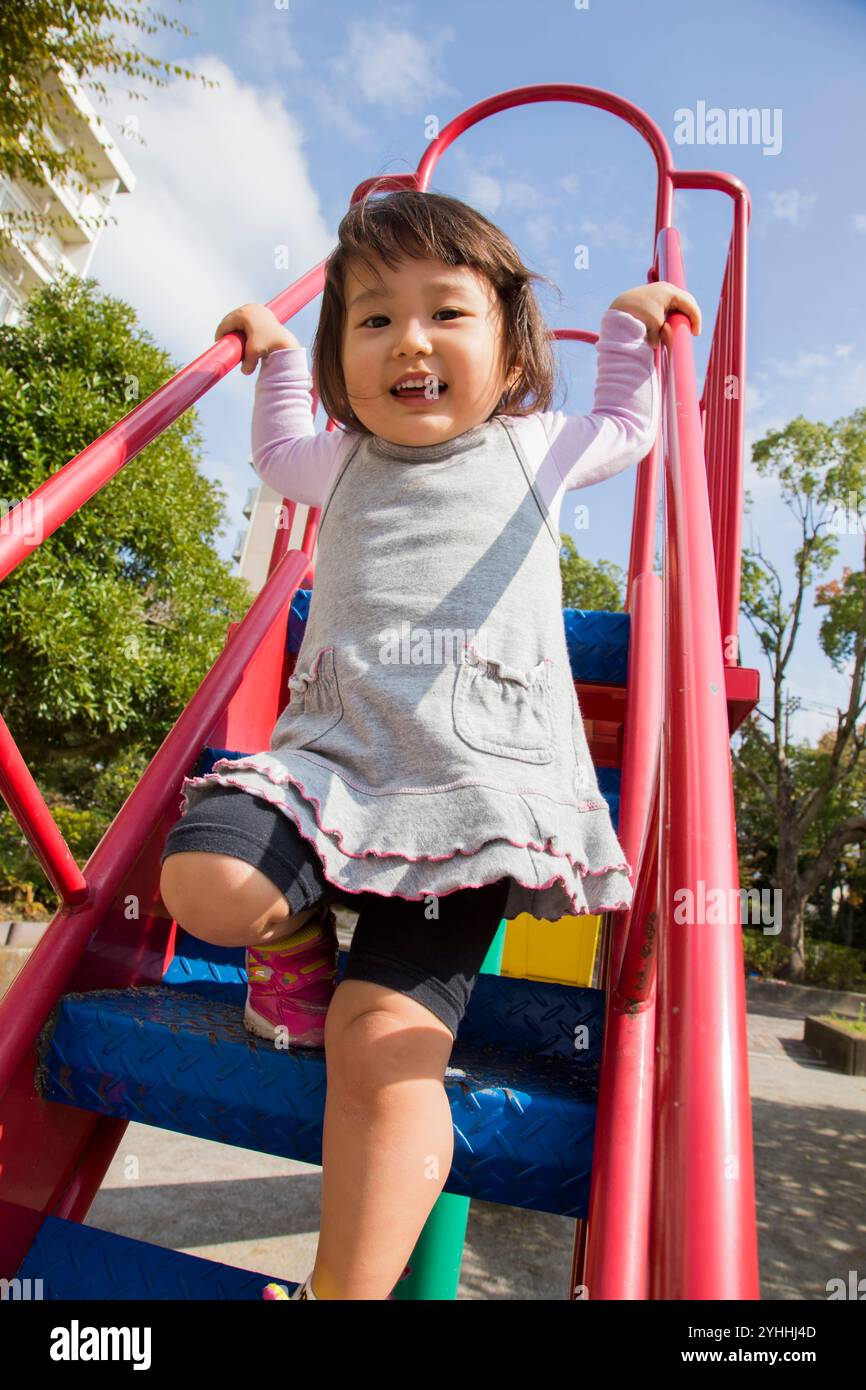 Girl playing on the slide Stock Photo - Alamy