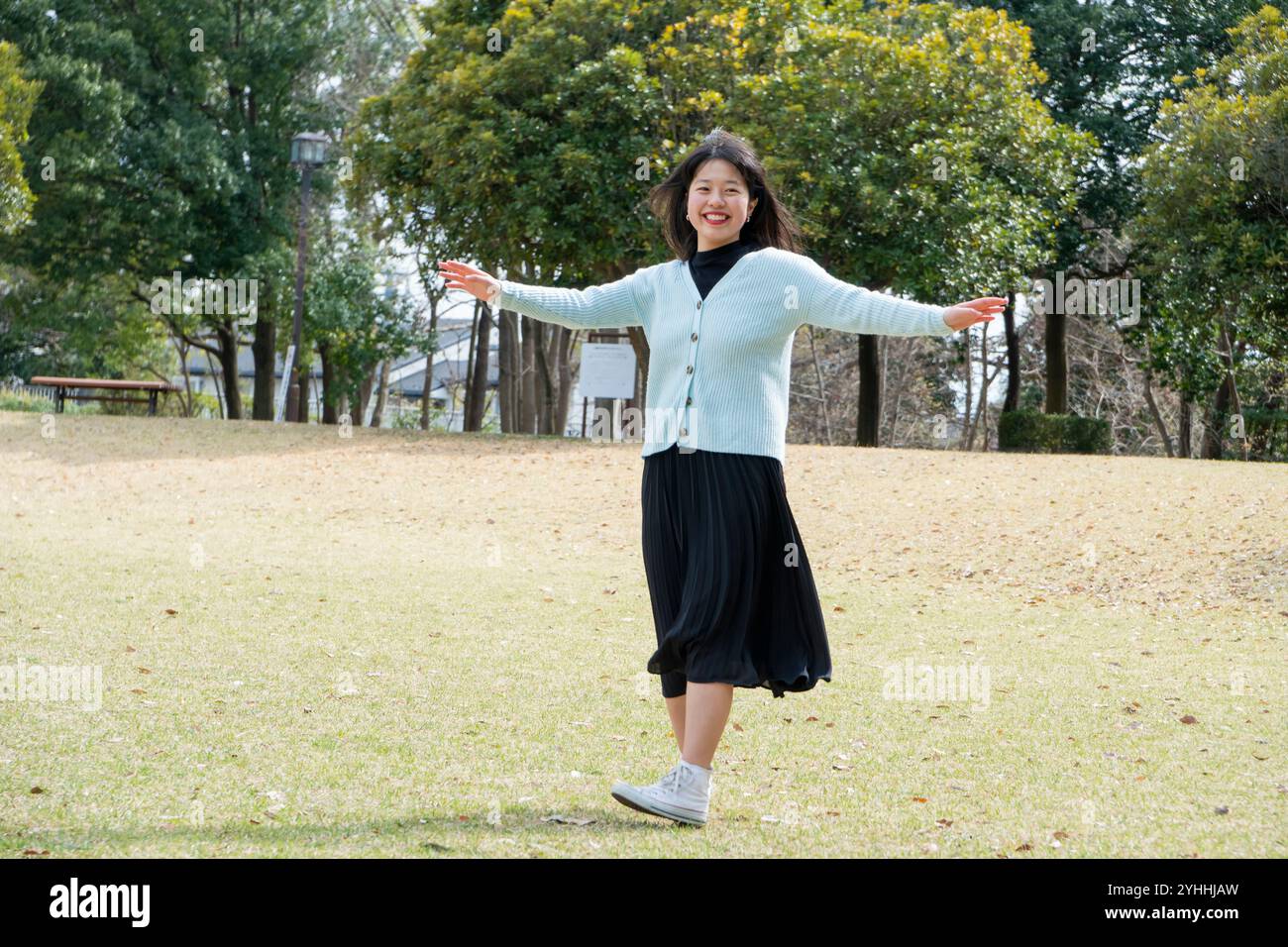Woman laughing with open arms in park Stock Photo - Alamy