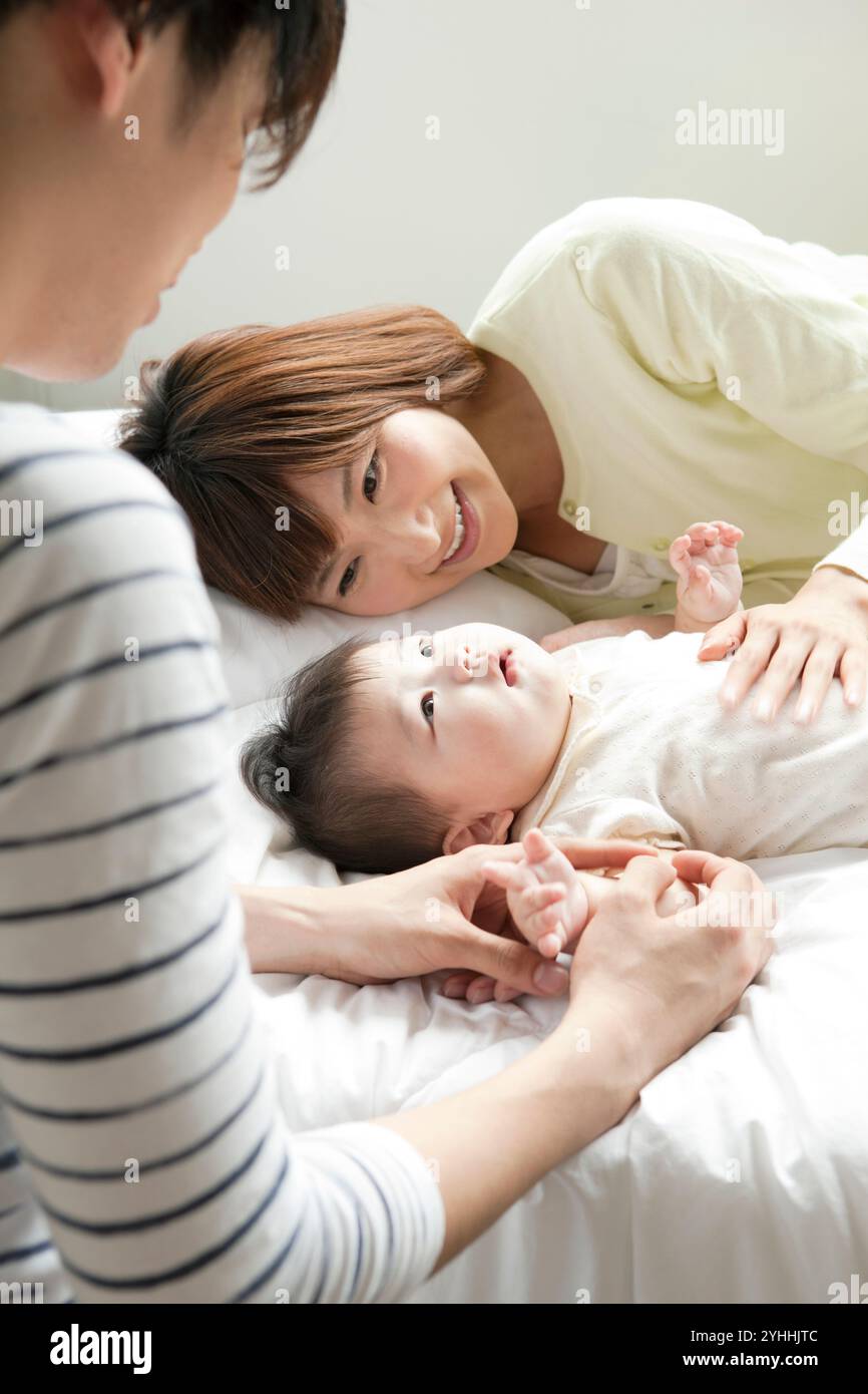 Mother and father nursing their child Stock Photo - Alamy