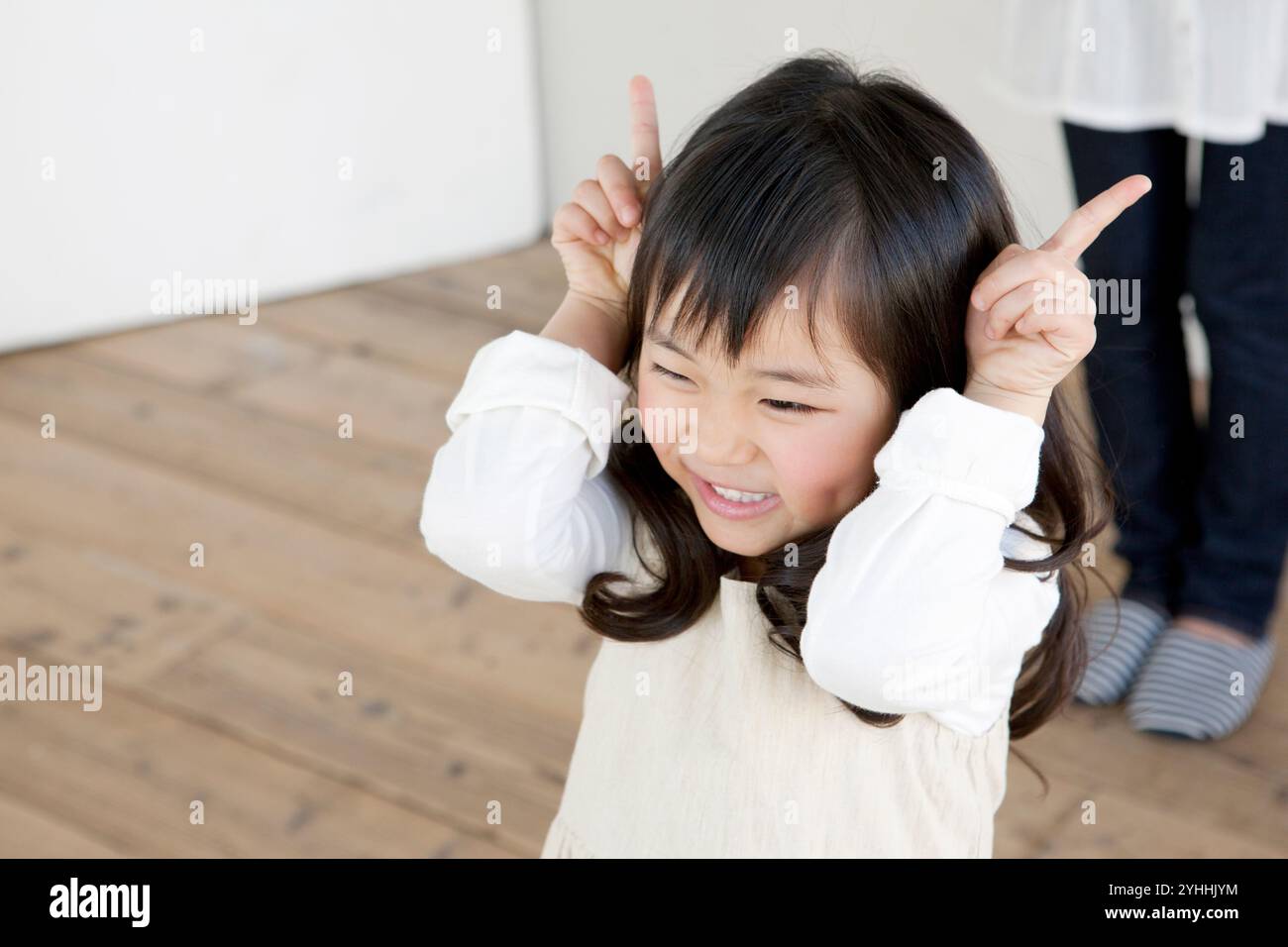 Girl posing with index finger raised Stock Photo - Alamy