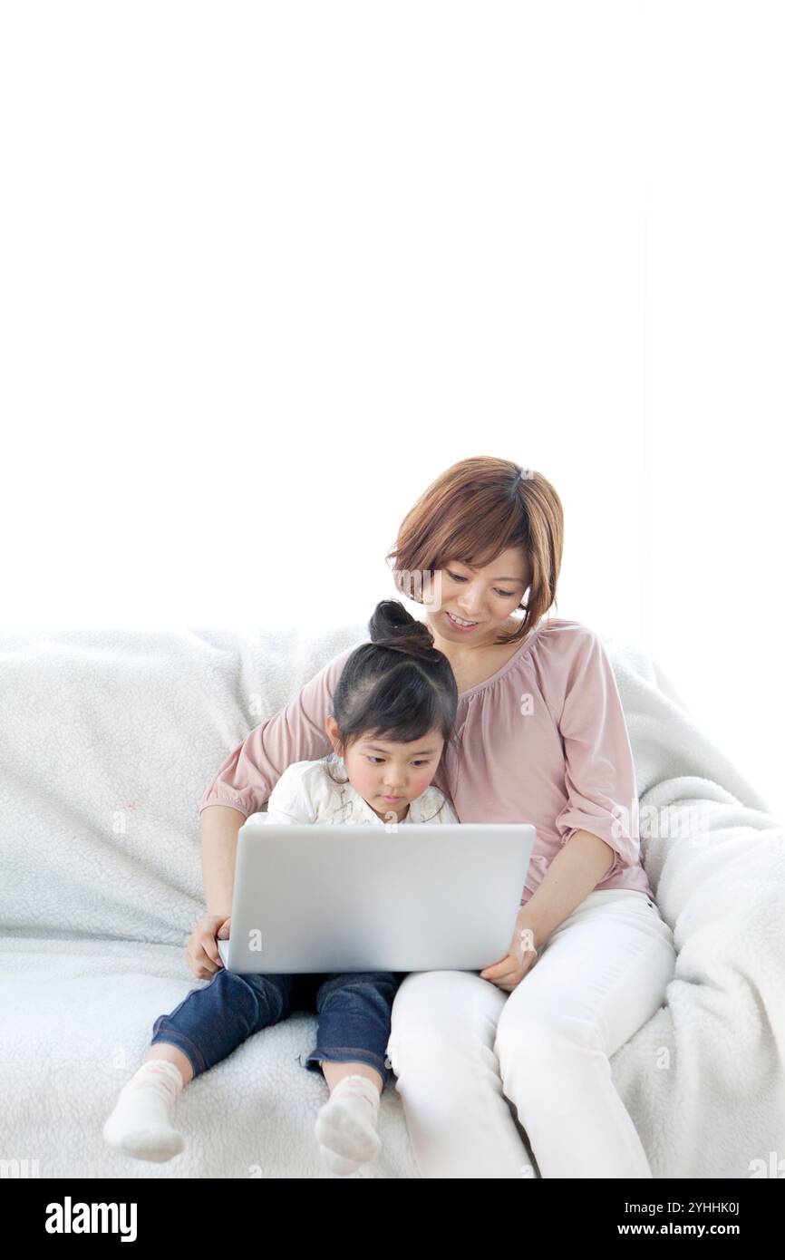 Mother and child facing computer Stock Photo - Alamy