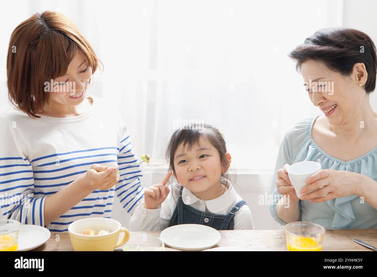 Family of three generations eating Stock Photo - Alamy