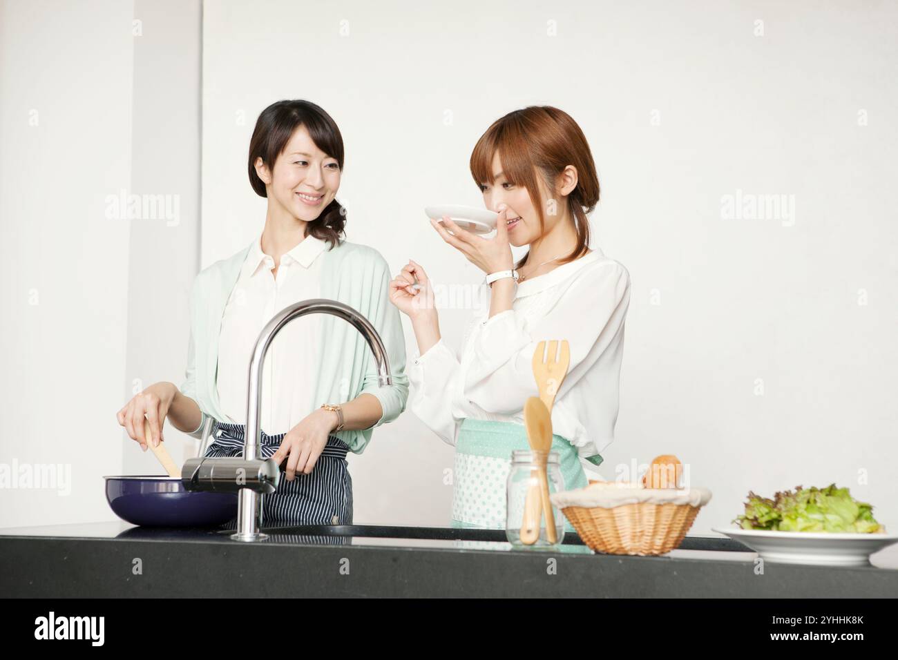 Woman tasting food while cooking Stock Photo - Alamy