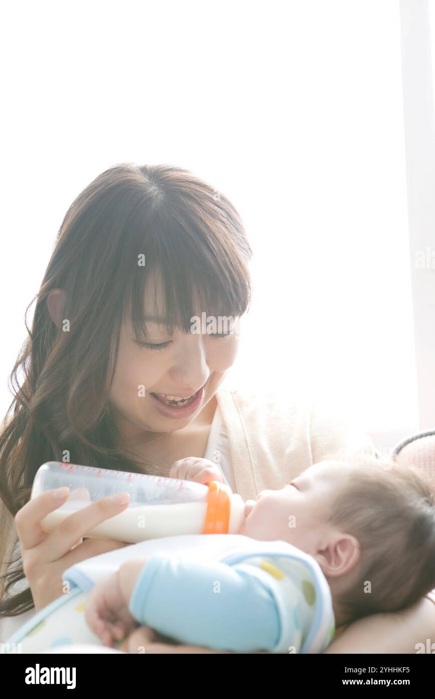 Mother giving milk to baby Stock Photo - Alamy