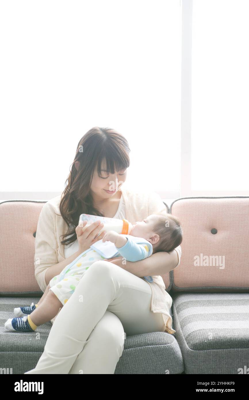 Mother giving milk to baby Stock Photo - Alamy
