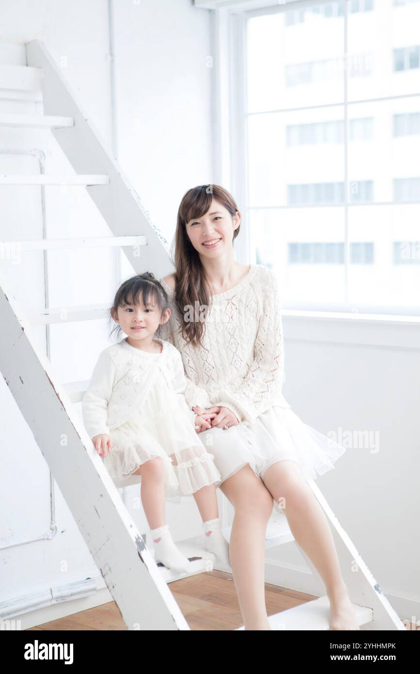 Mother and daughter sitting on ladder Stock Photo - Alamy