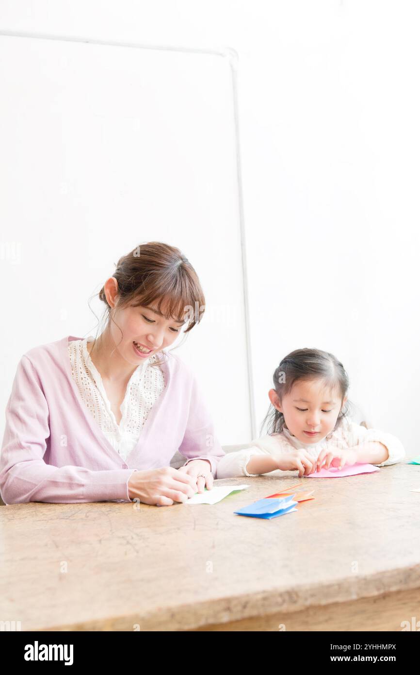 Mother and daughter doing origami together Stock Photo - Alamy