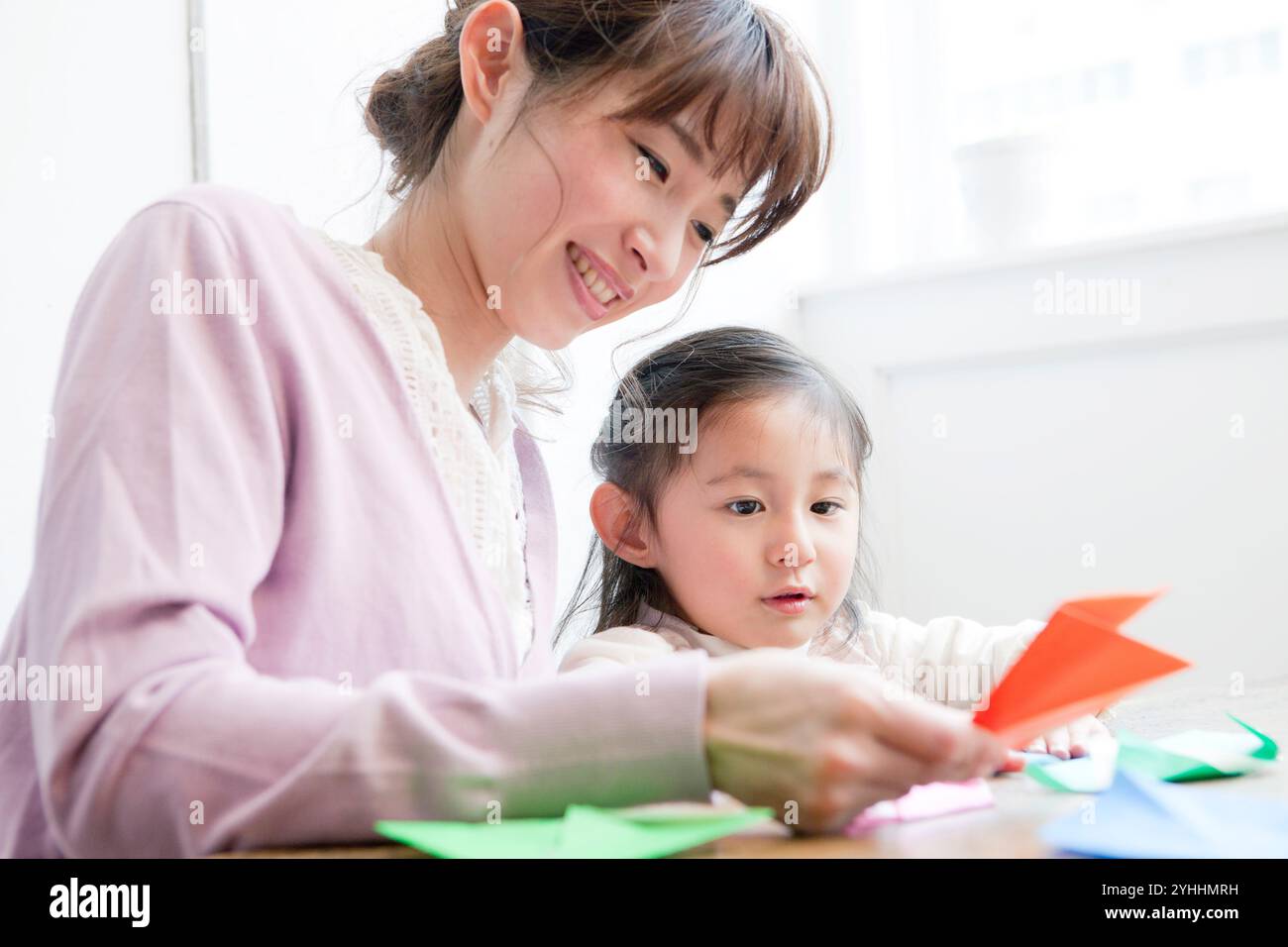 Mother and daughter doing origami together Stock Photo - Alamy