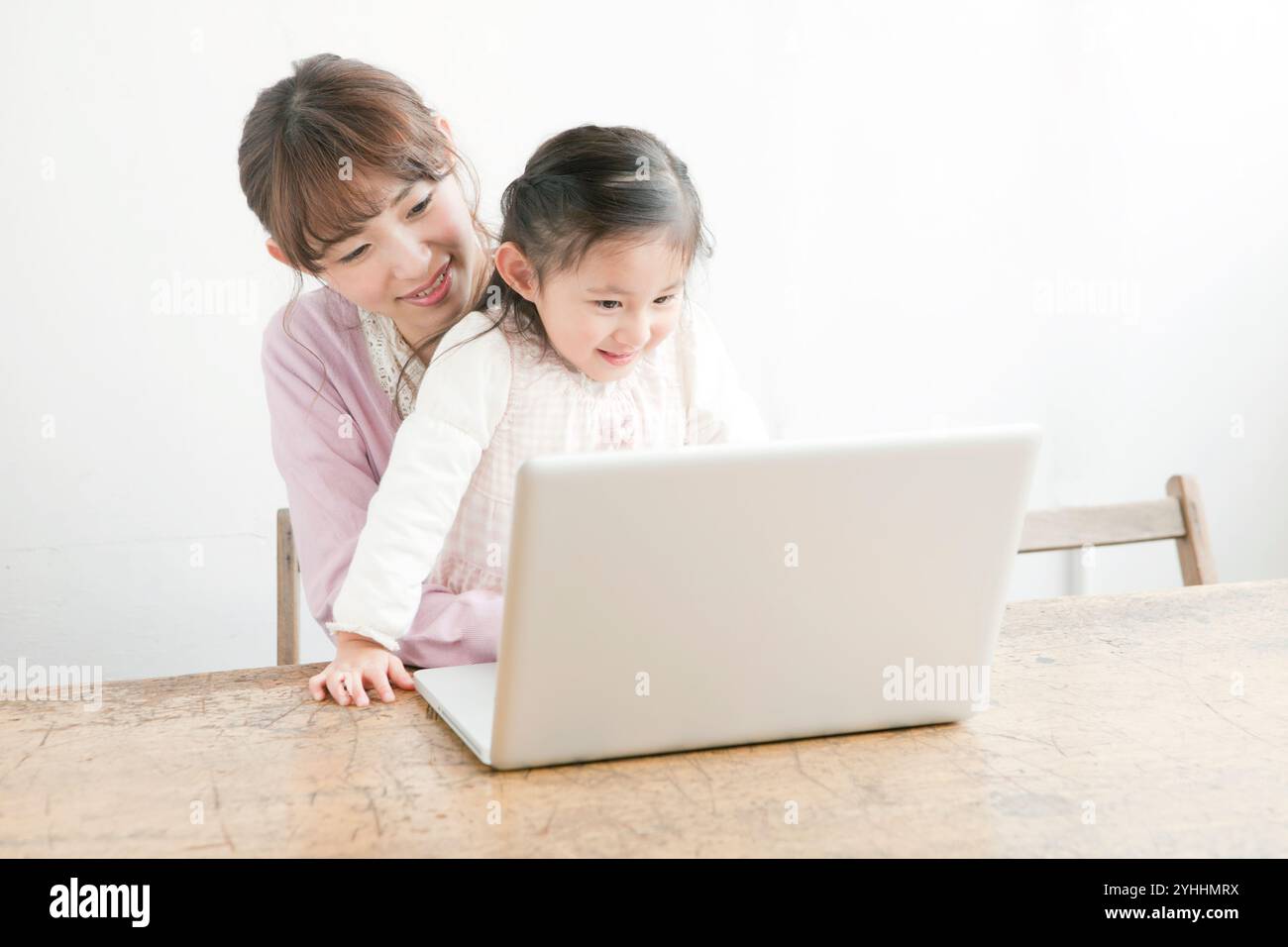Mother and daughter looking at a computer screen together Stock Photo ...