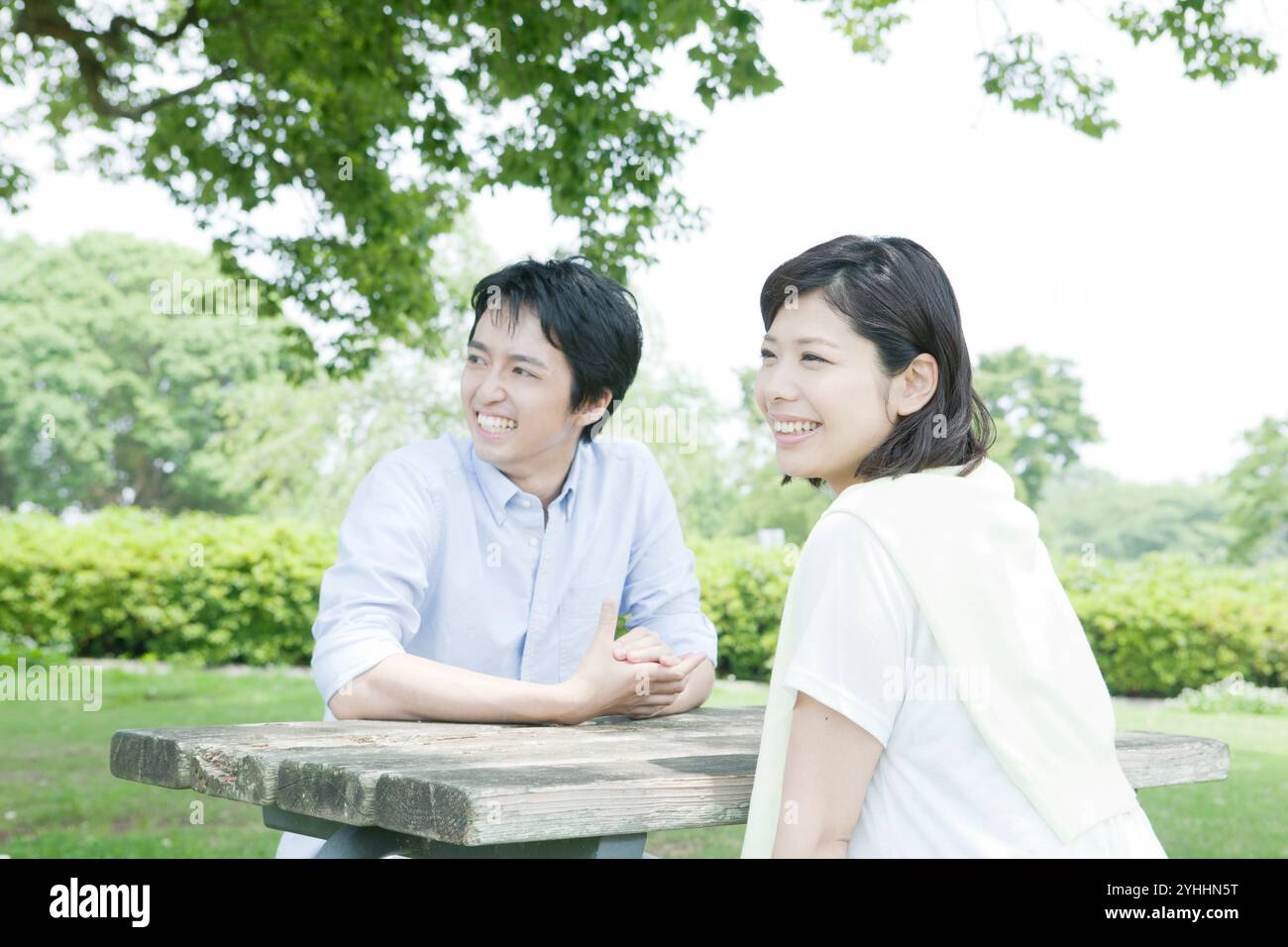 Couple sitting at park table Stock Photo - Alamy