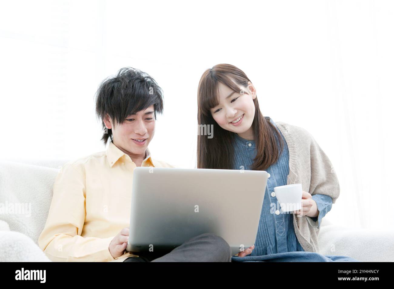 Couple in their 20s sitting side by side on computers Stock Photo - Alamy