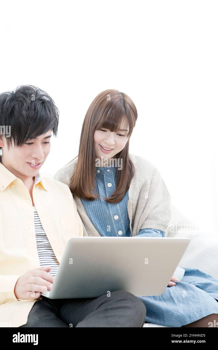 Couple in their 20s sitting side by side on computers Stock Photo - Alamy