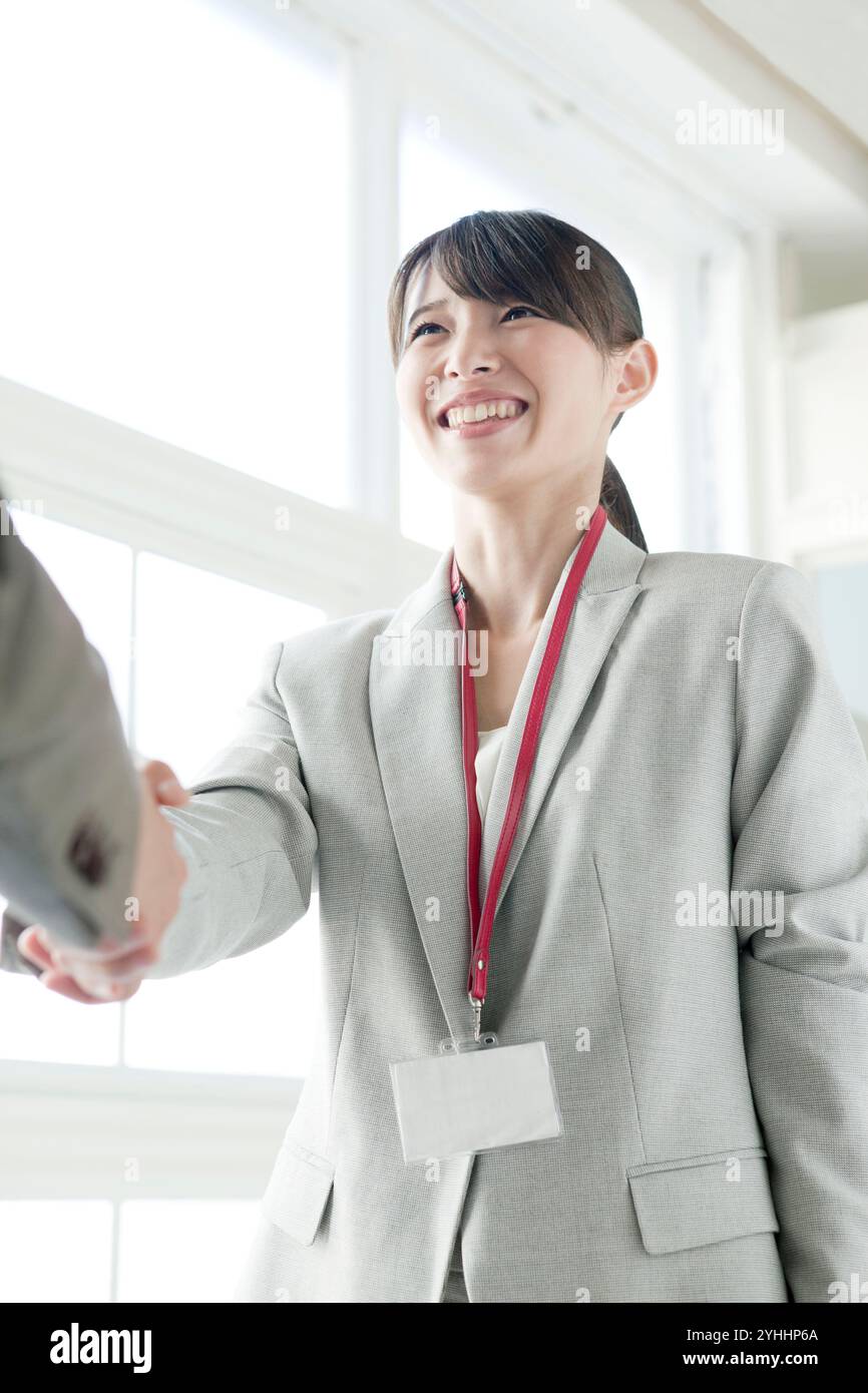 Female office worker shaking hands Stock Photo - Alamy