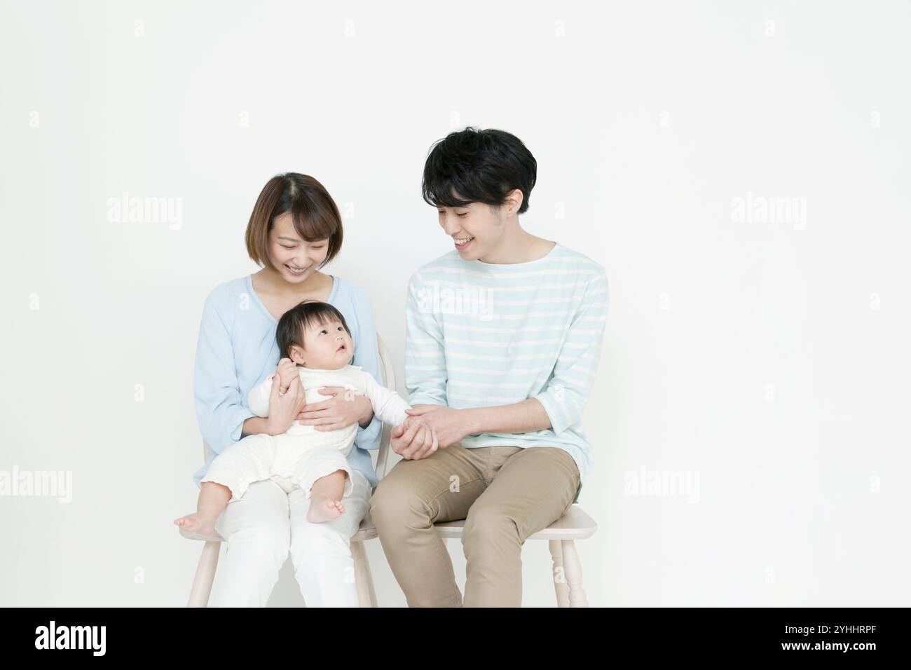Three parents and children sitting on chairs Stock Photo - Alamy