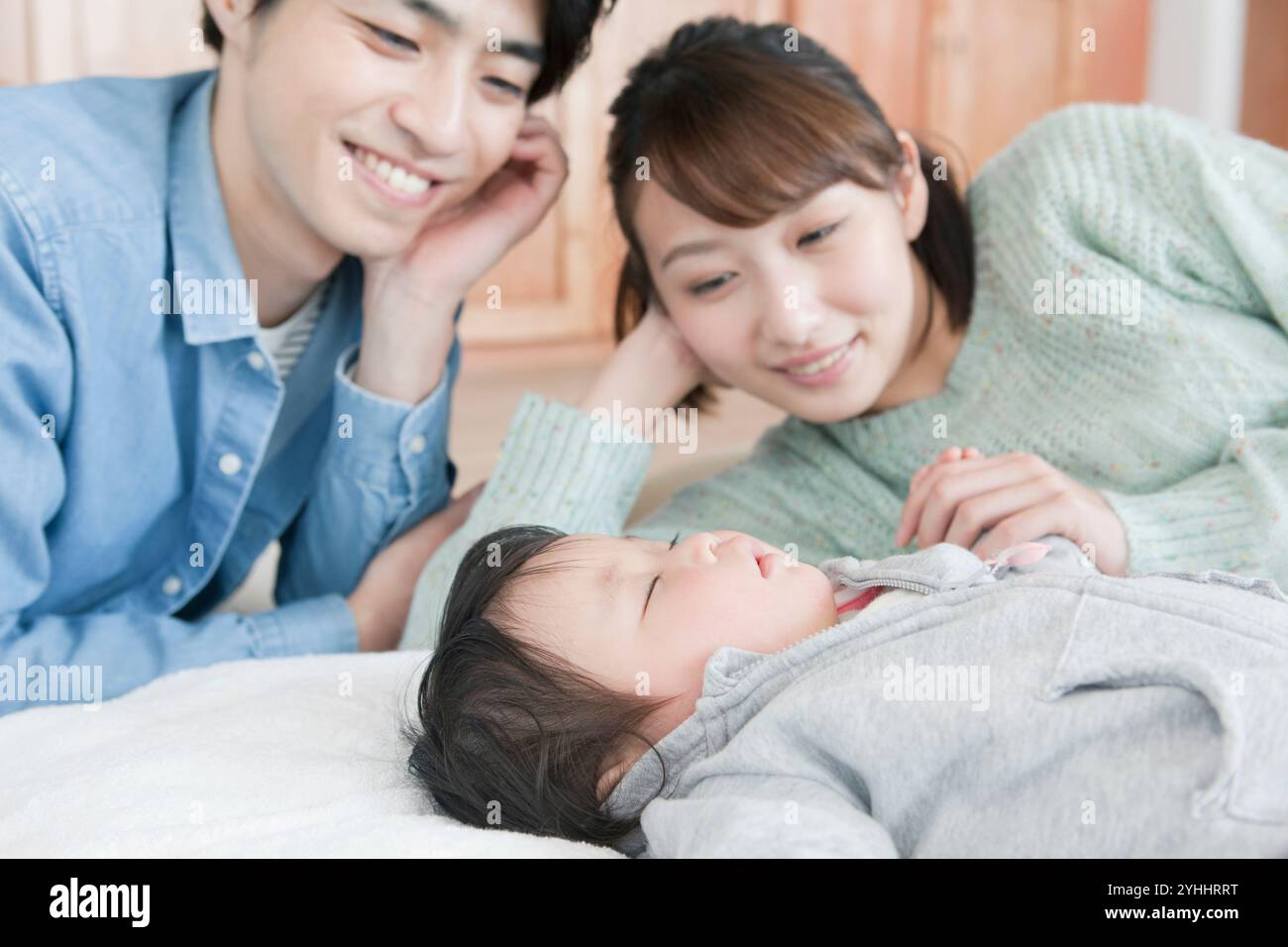 Sleeping child and couple in their 20s Stock Photo - Alamy