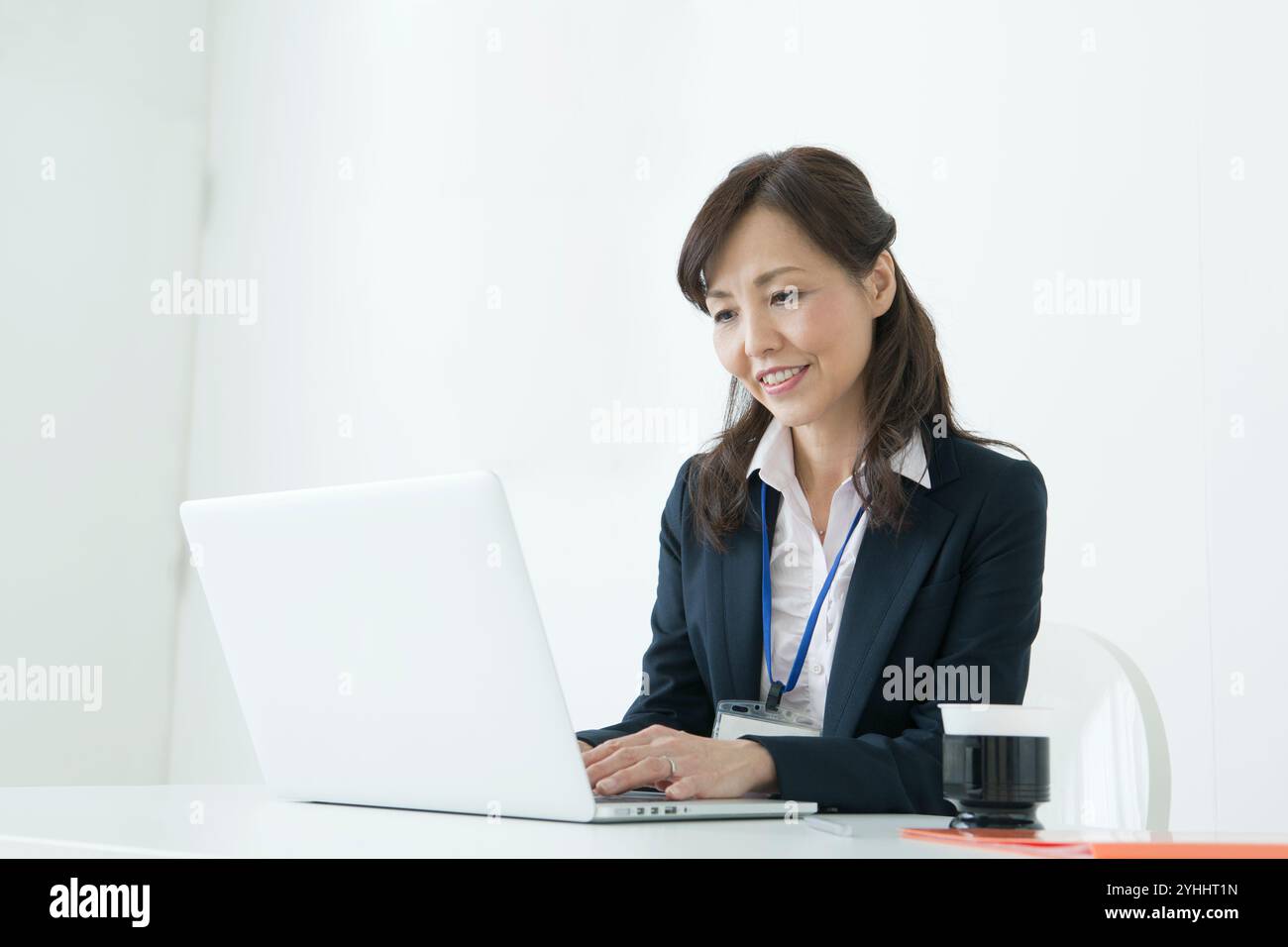 Woman in a suit in her 50s operating a computer Stock Photo - Alamy