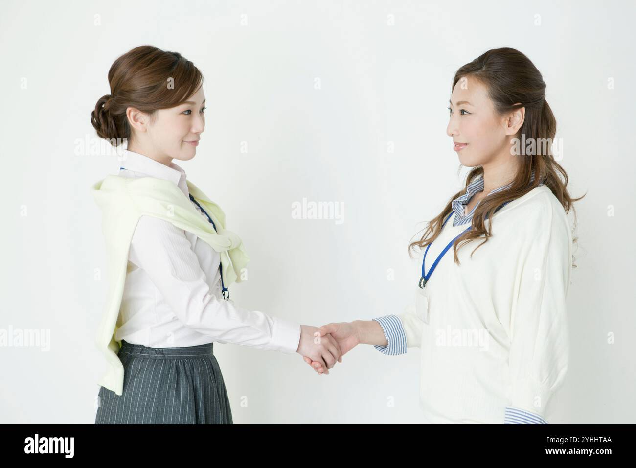 Two women in their 20s shaking hands Stock Photo - Alamy