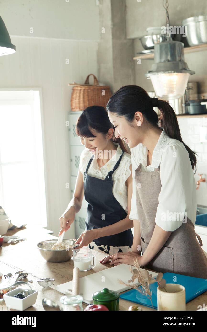 Two women in their 20s making sweets Stock Photo - Alamy