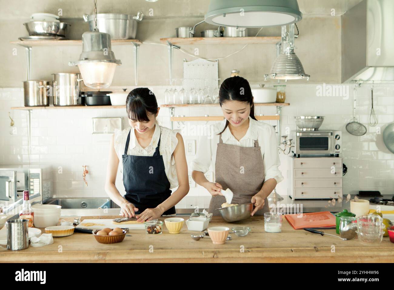 Two women in their 20s making sweets Stock Photo - Alamy