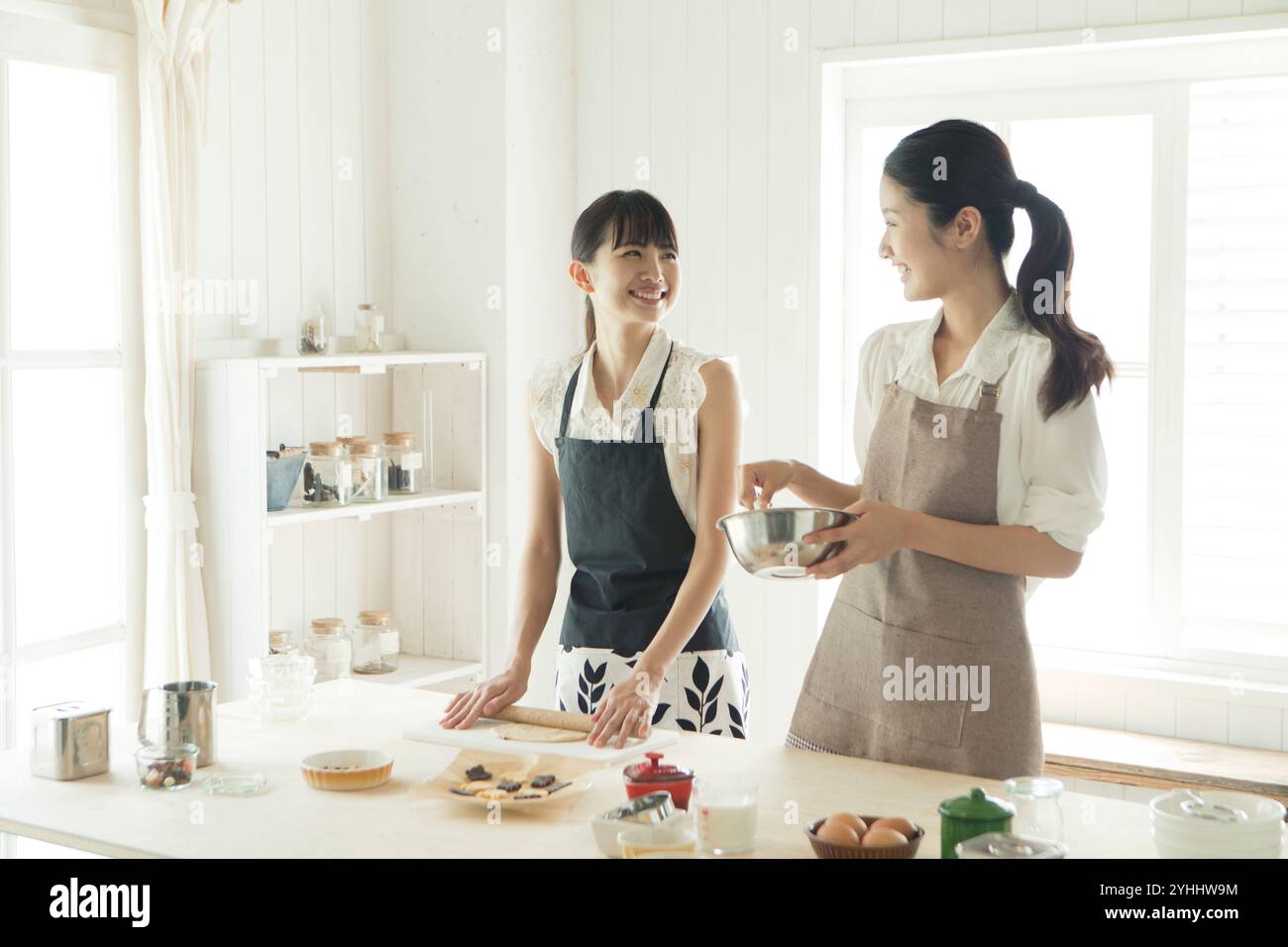 Two women in their 20s making sweets Stock Photo - Alamy