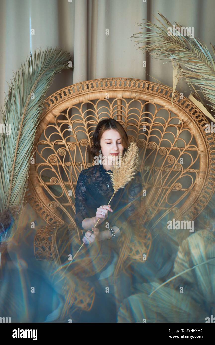 a teenage girl in a dress in a romantic location with dry reed stalks ...