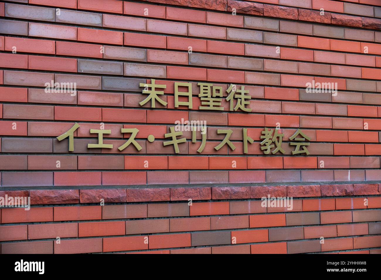 Sign indicating a church with Japanese characters on a brick wall in an ...