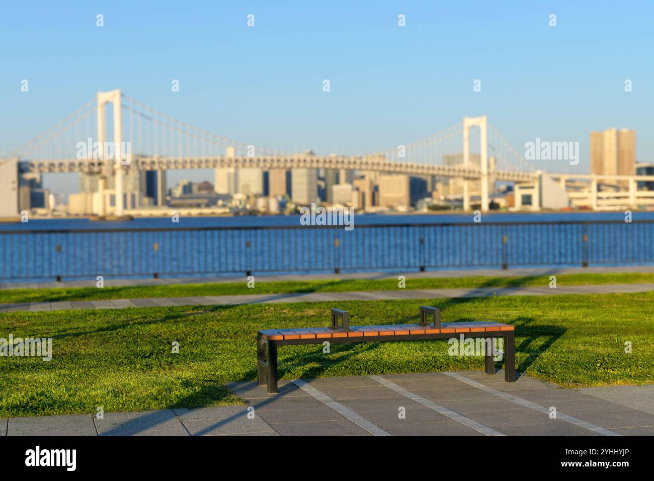 Benches in Toyosu Gururi Park and Rainbow Bridge in the morning sun ...
