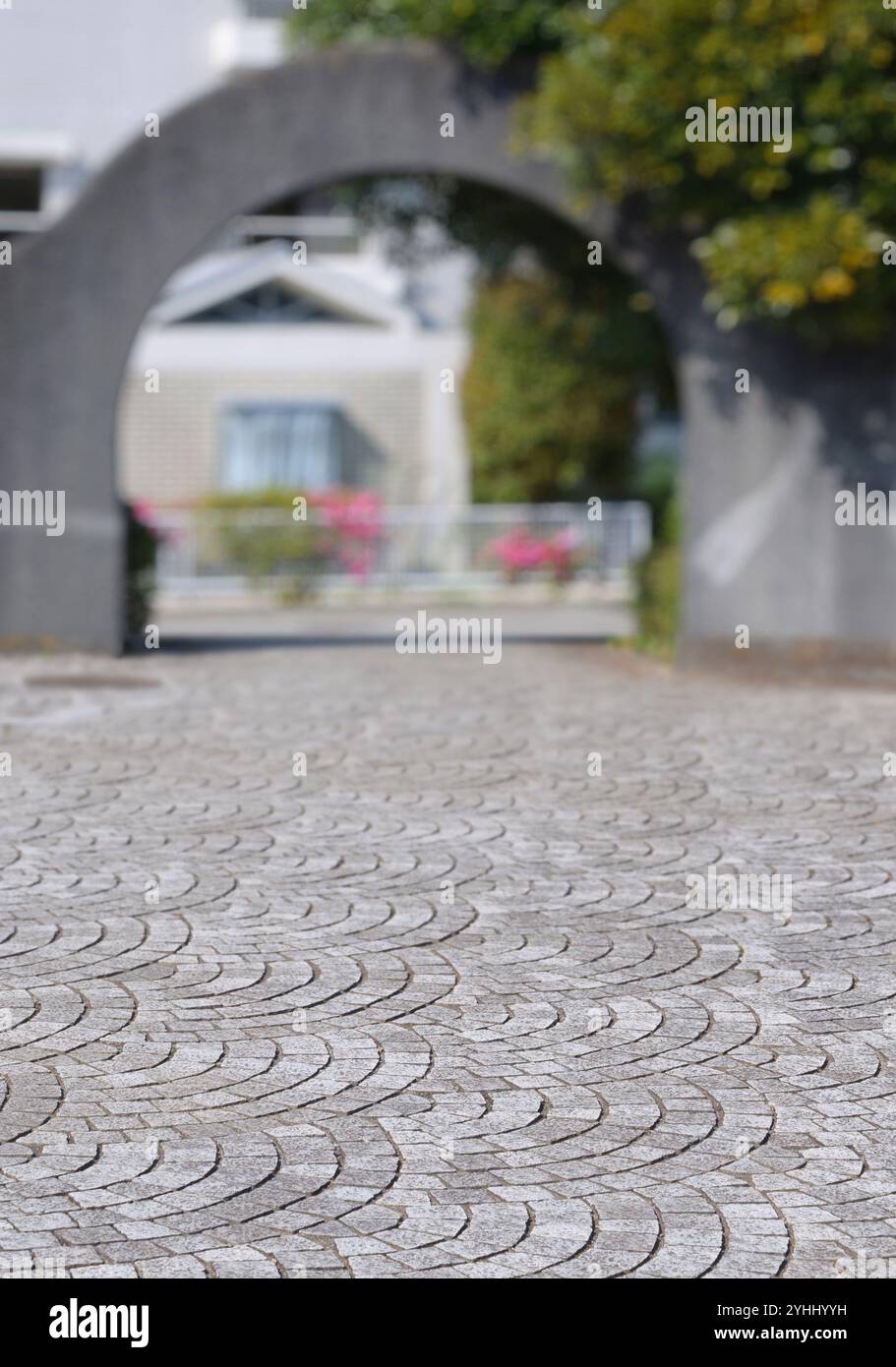 Cobblestone square and arched entrance to park Stock Photo - Alamy