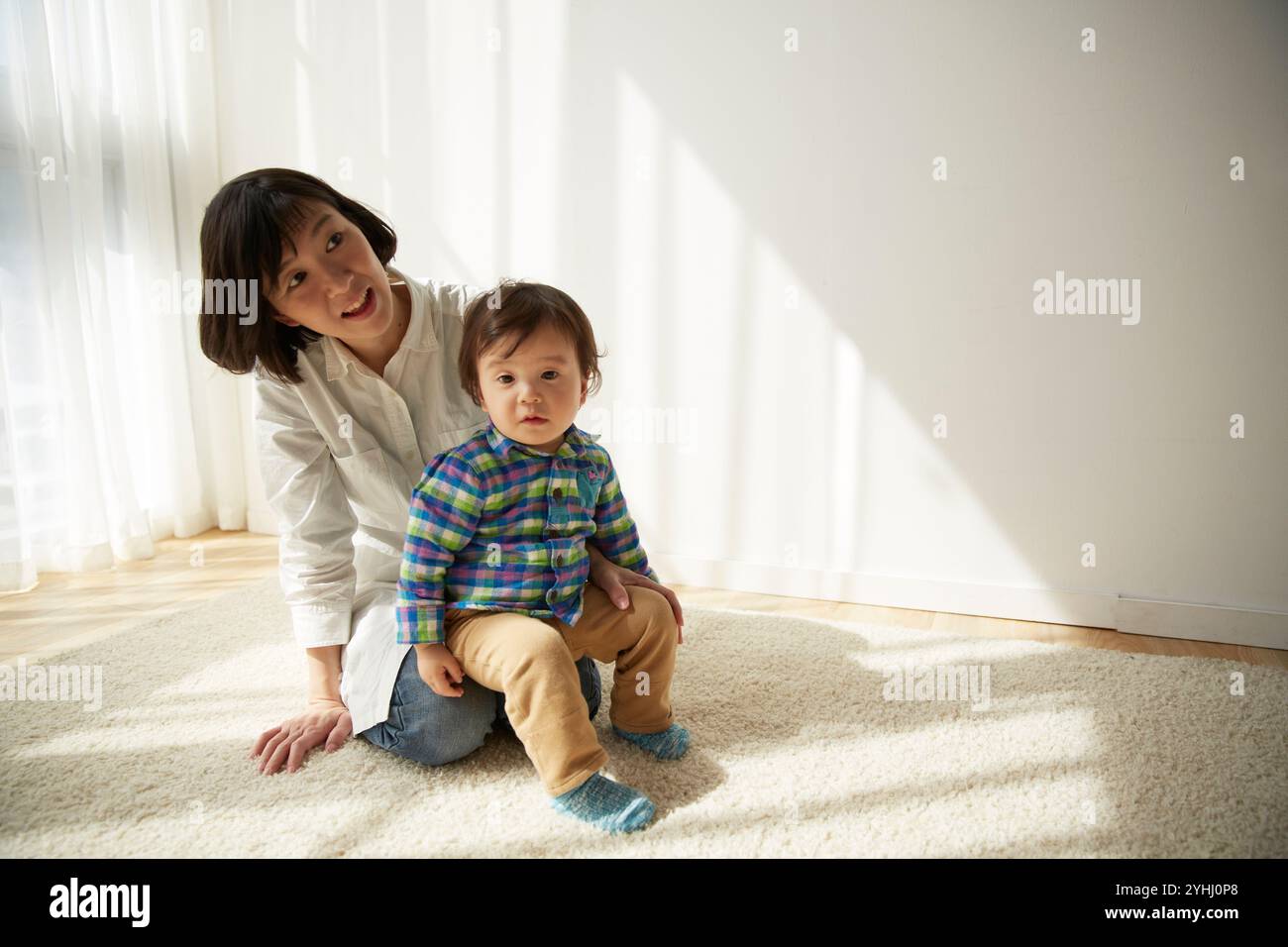 Boy sitting on his mother's lap Stock Photo - Alamy