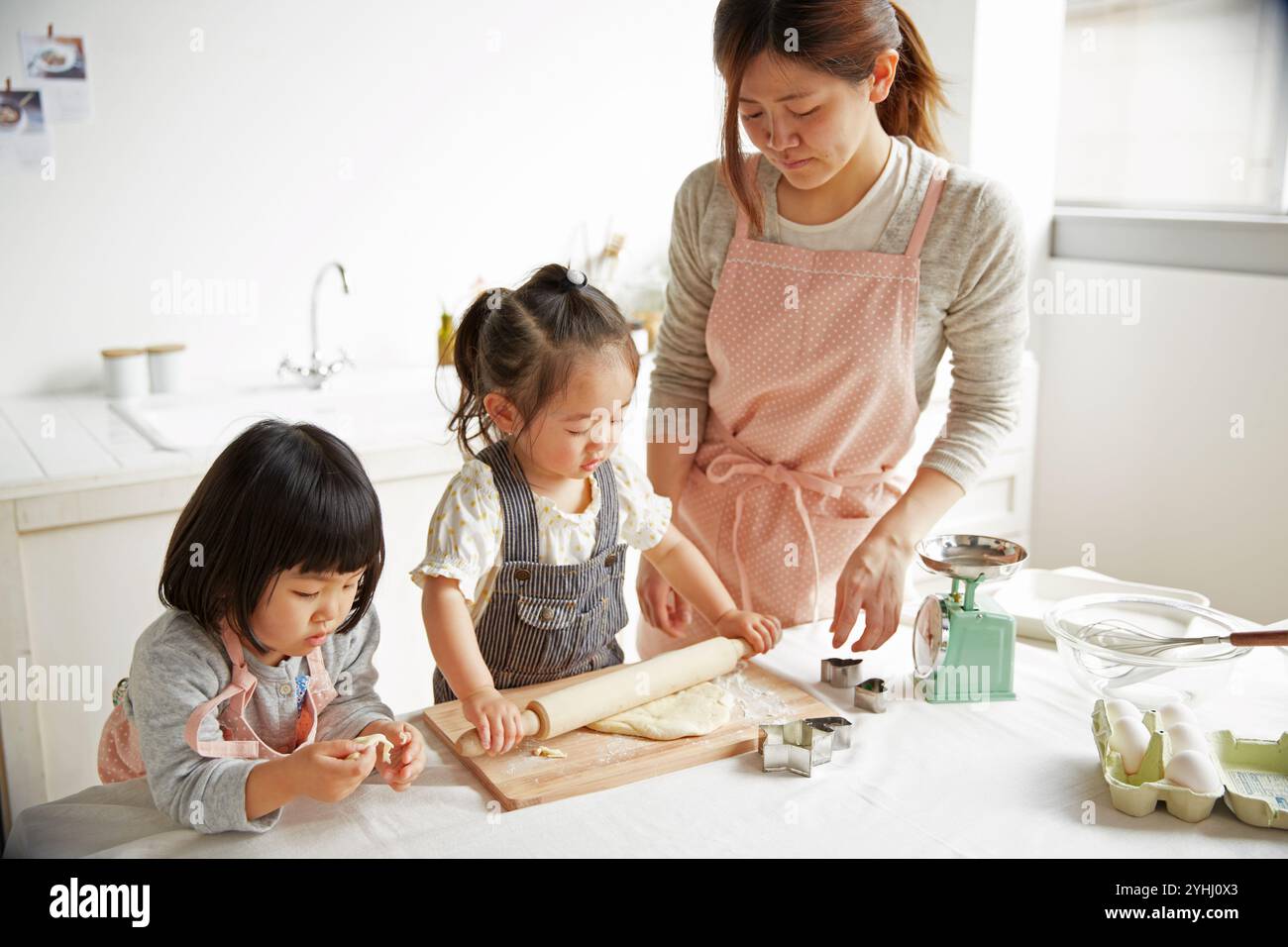 Two girls cooking with their sister Stock Photo - Alamy