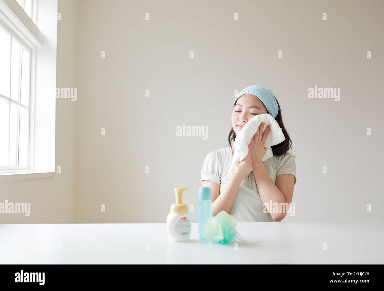 Young woman wiping her face Stock Photo - Alamy