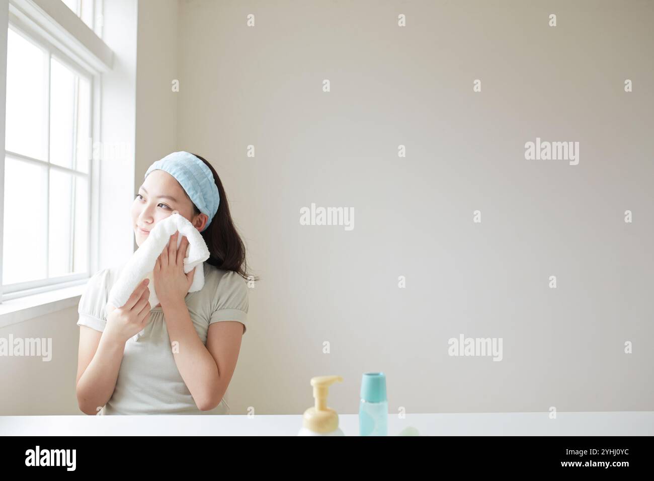Young woman wiping her face Stock Photo - Alamy