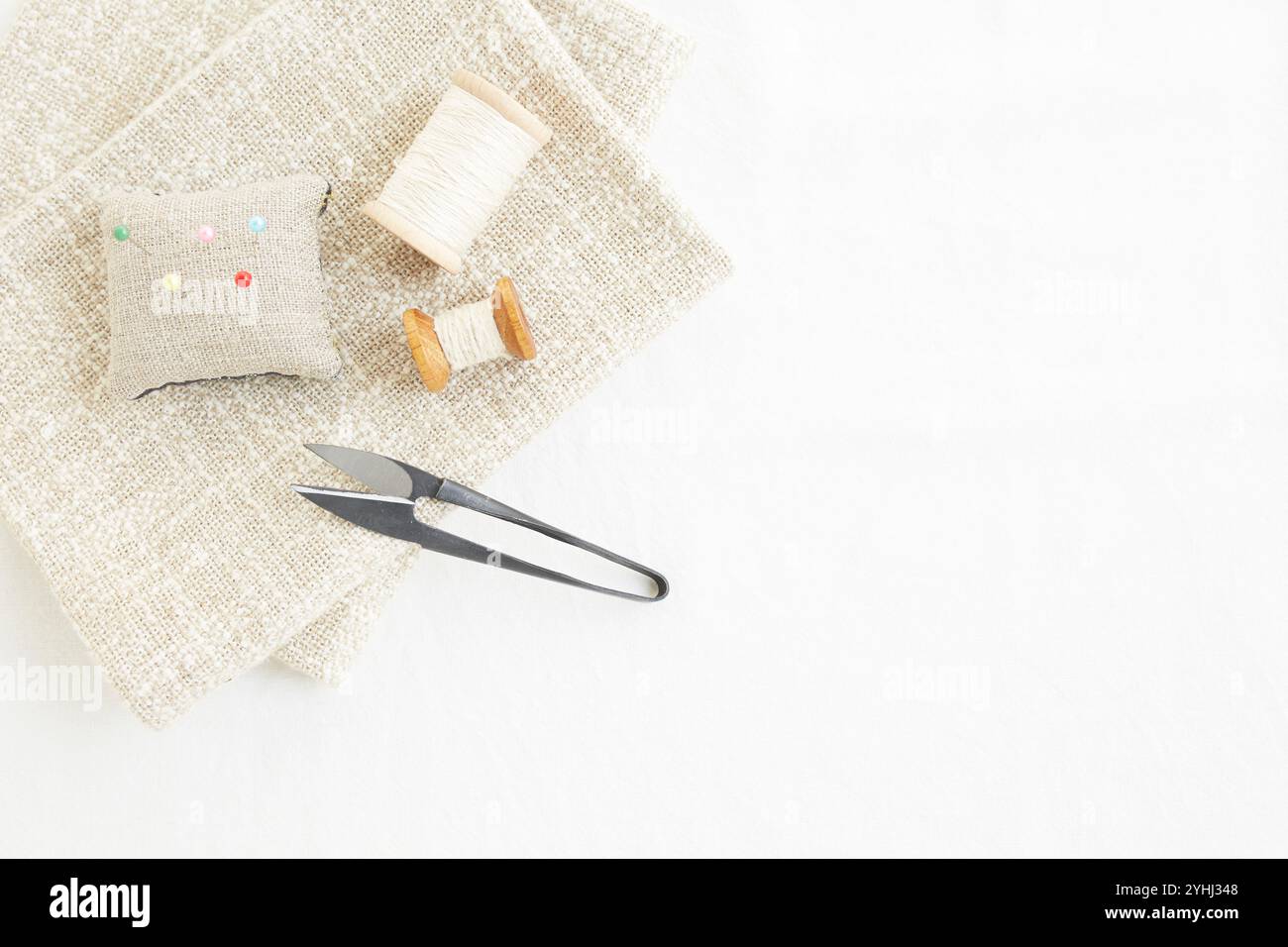 Sewing thread, needle, scissors and cloth Stock Photo - Alamy