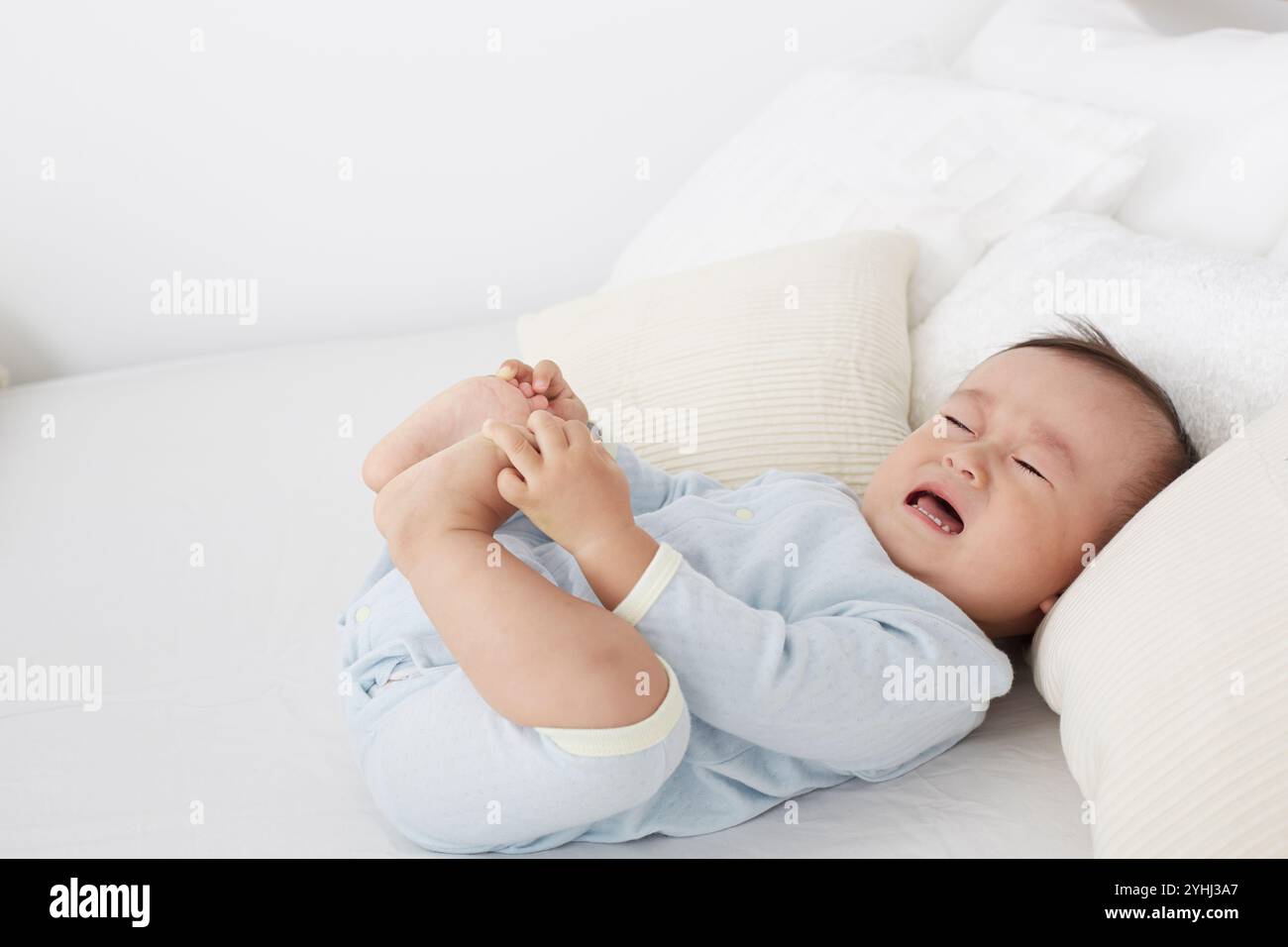 Baby crying on bed Stock Photo - Alamy