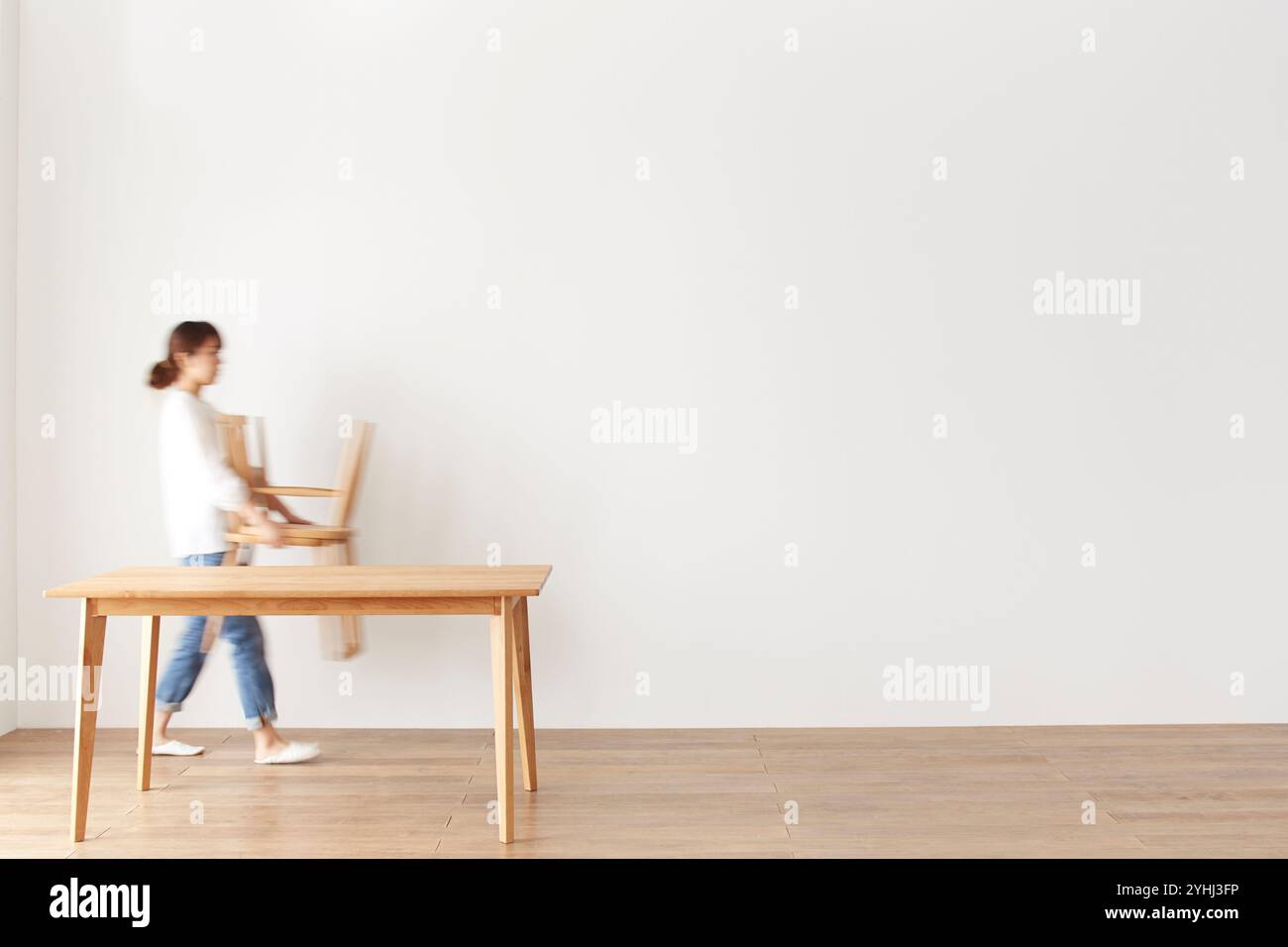 Woman carrying dining table and dining chairs Stock Photo - Alamy