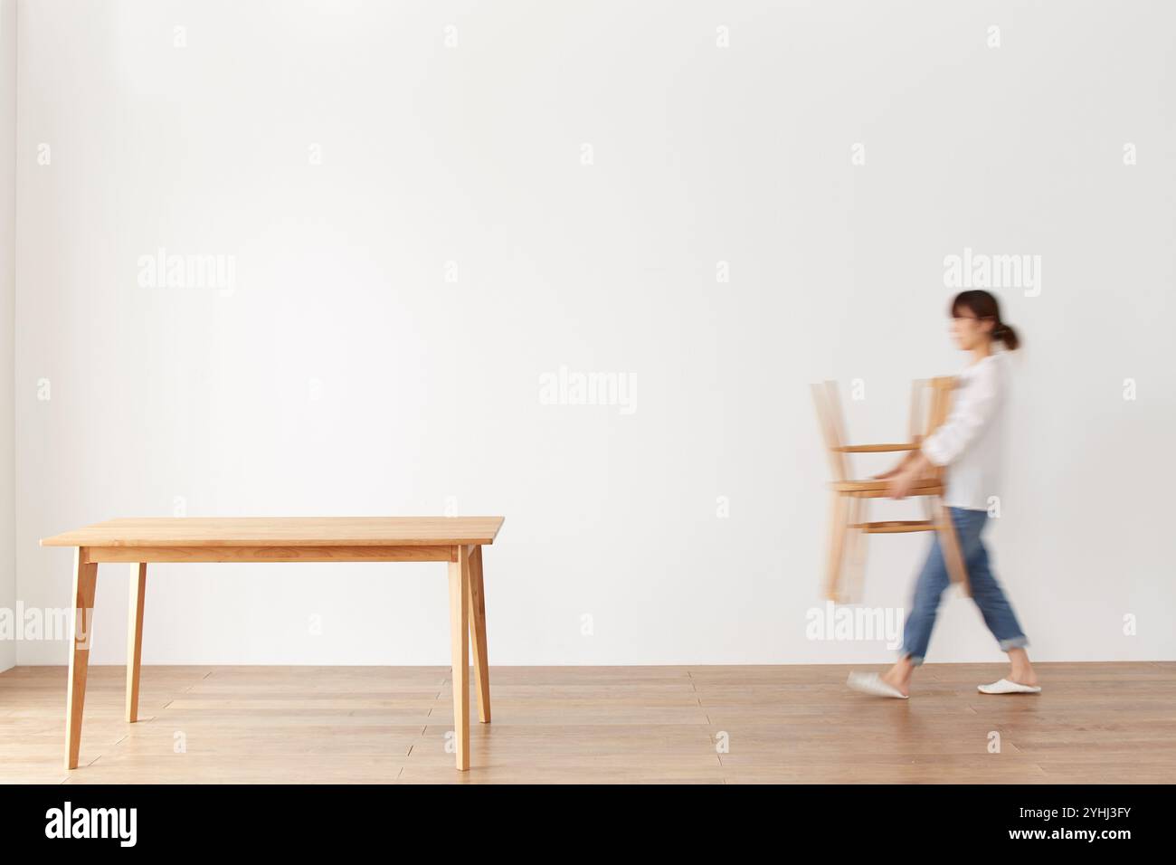 Woman carrying dining table and dining chairs Stock Photo - Alamy