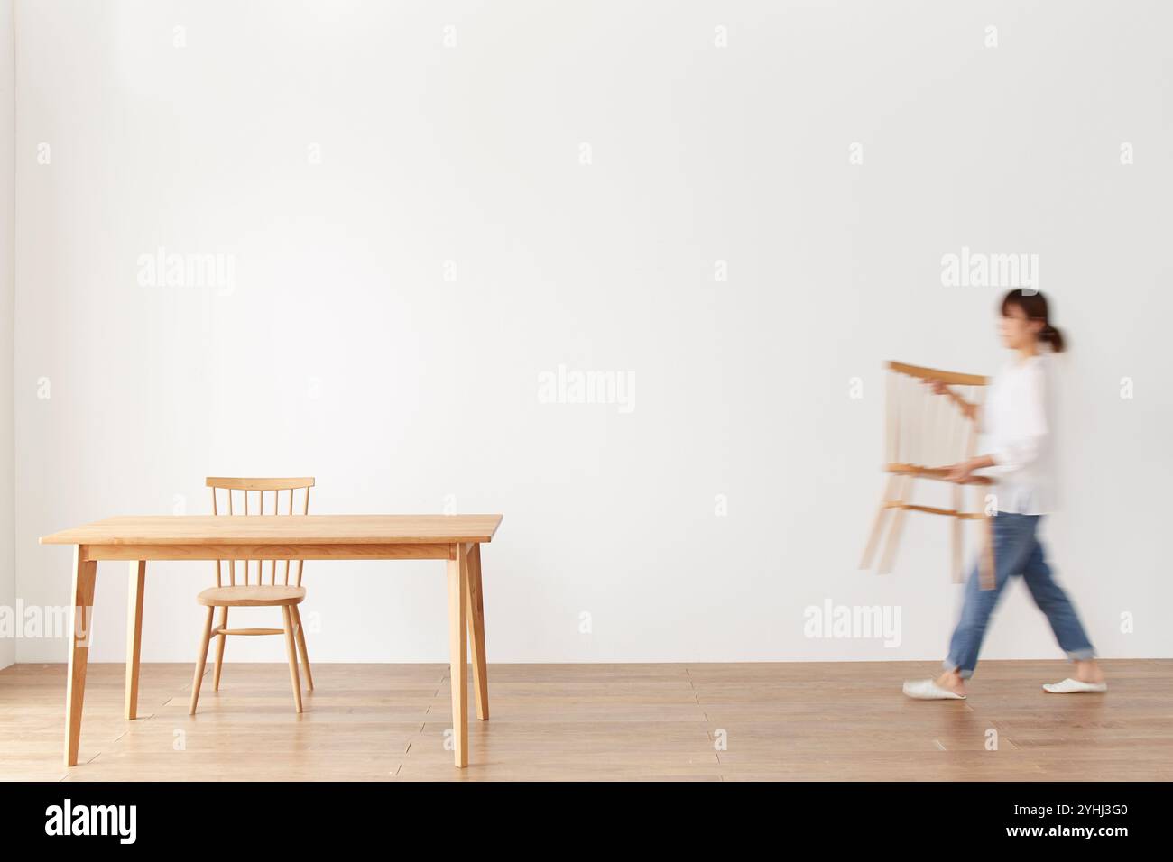 Woman carrying dining table and dining chairs Stock Photo - Alamy