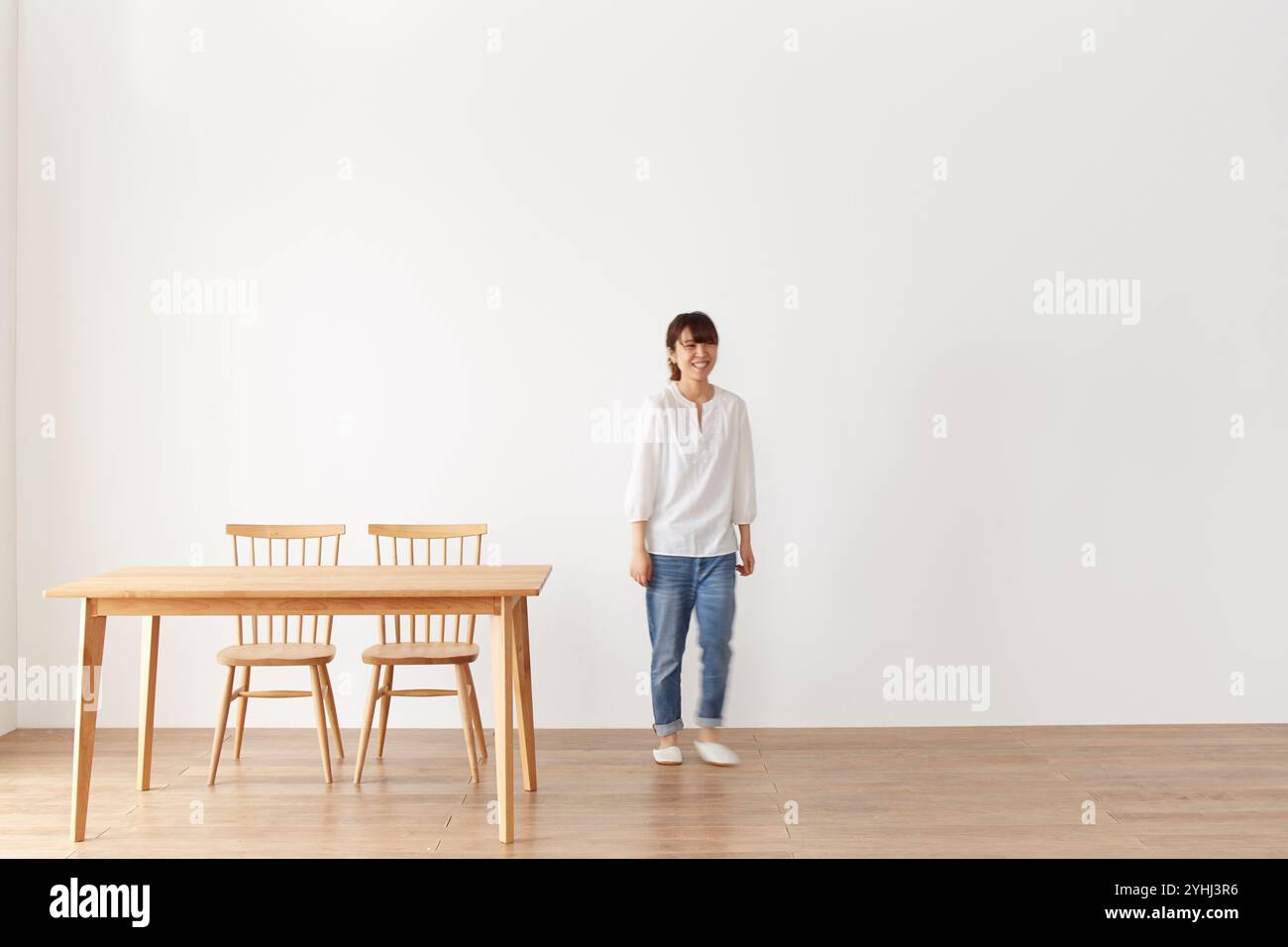 Woman standing next to dining table laughing Stock Photo - Alamy