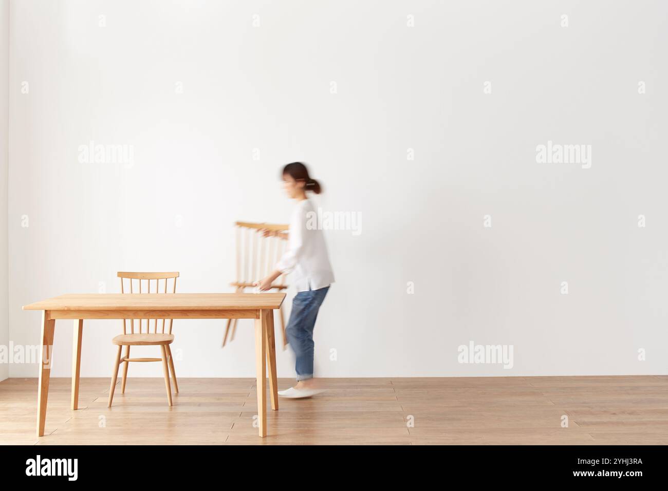 Woman carrying dining table and dining chairs Stock Photo - Alamy