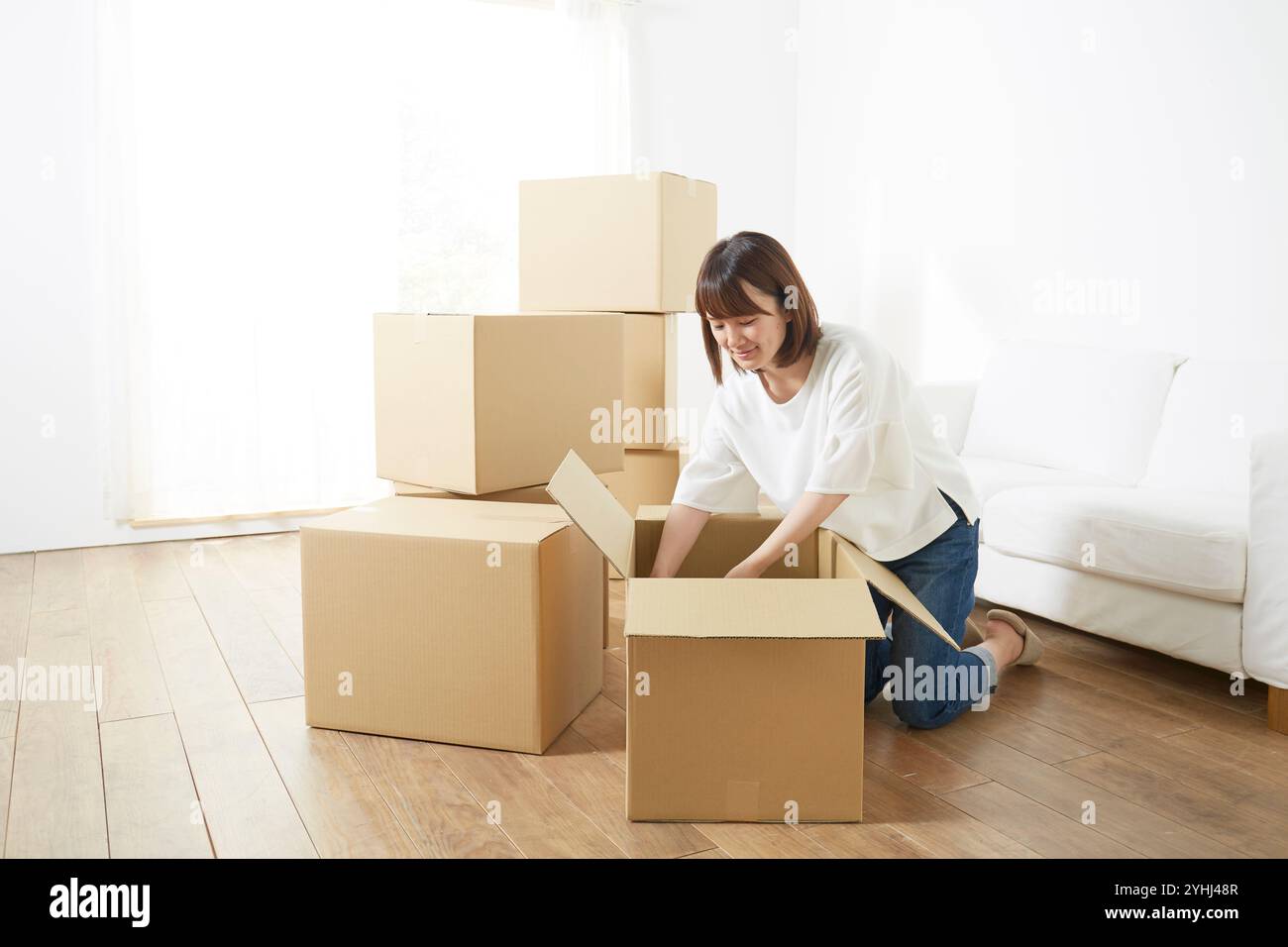 Woman removing items from cardboard boxes for moving Stock Photo - Alamy
