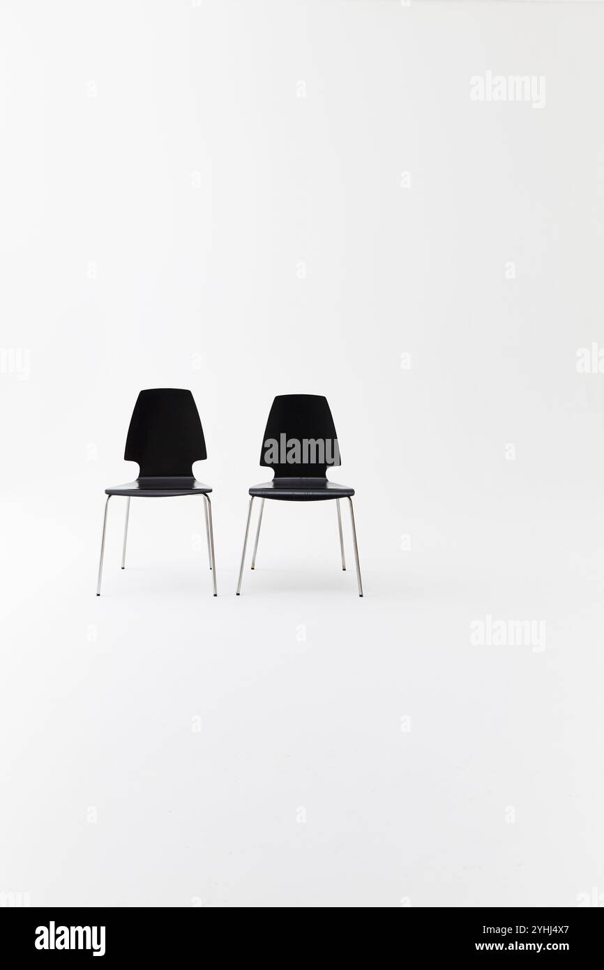 Two black chairs on white background Stock Photo - Alamy